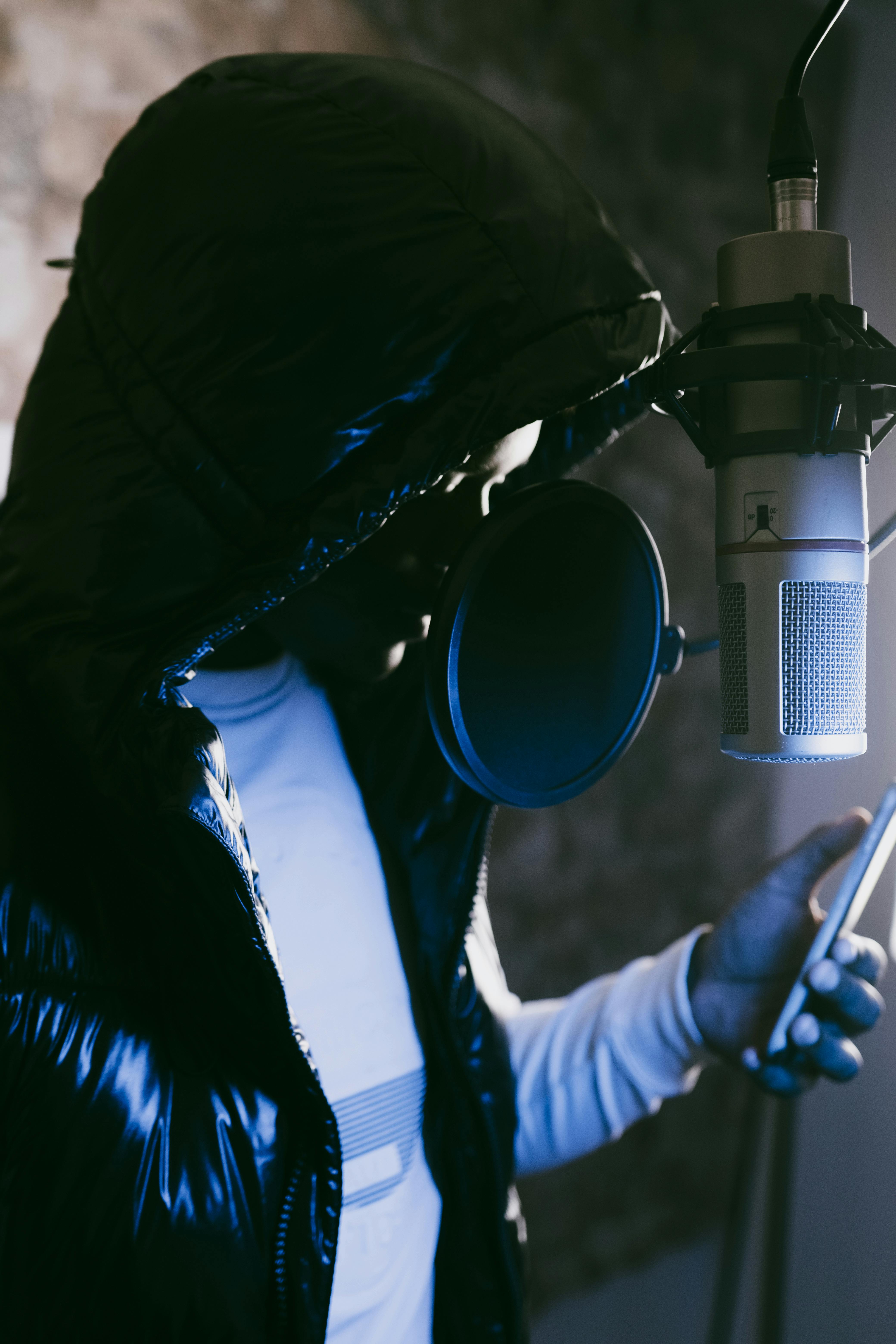 Person in Robes with Hood Standing with Puppets · Free Stock Photo