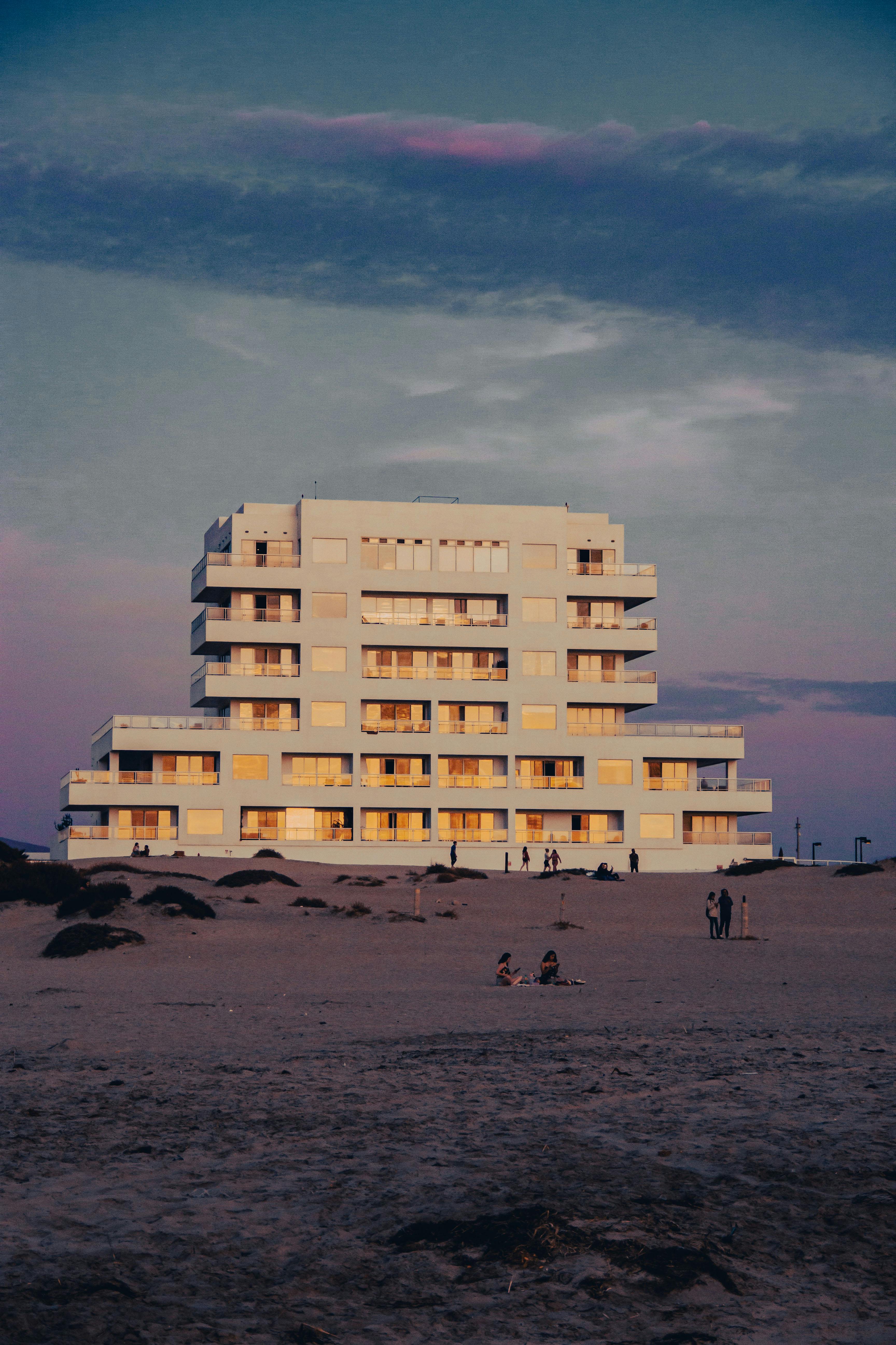 White Concrete Building on Beach Sand at Sunset · Free Stock Photo