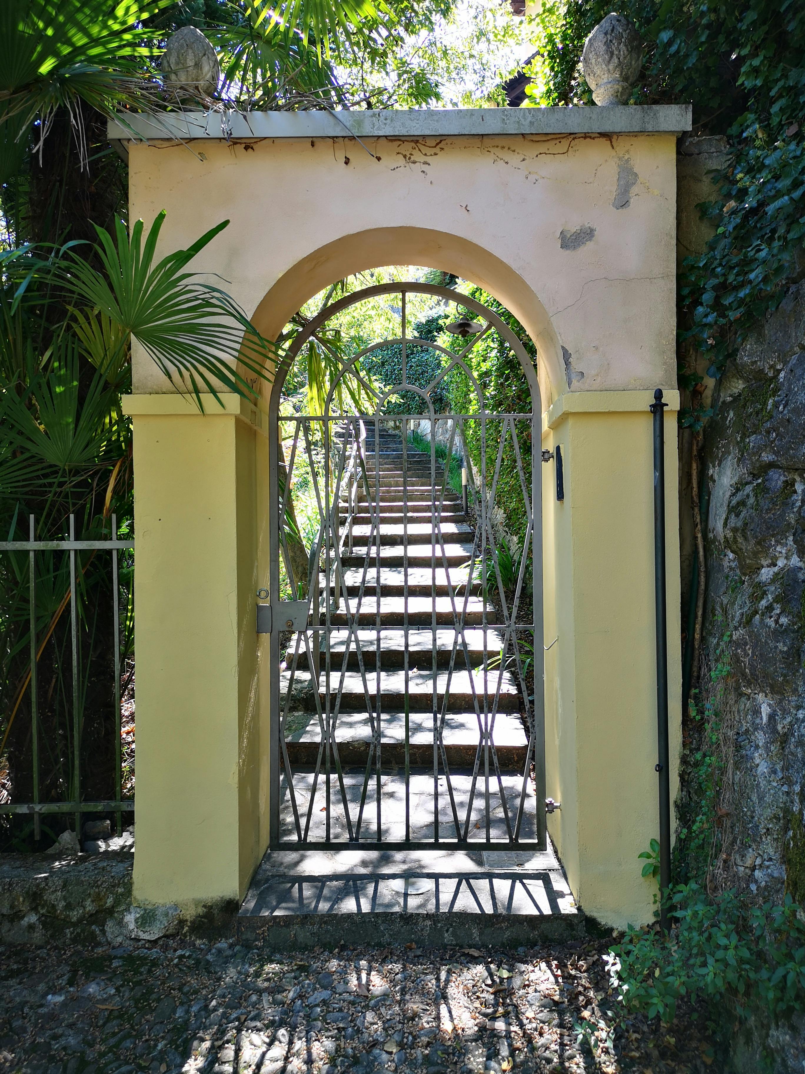 Entrance Gate to Garden Overgrown with Flower Bush · Free Stock Photo