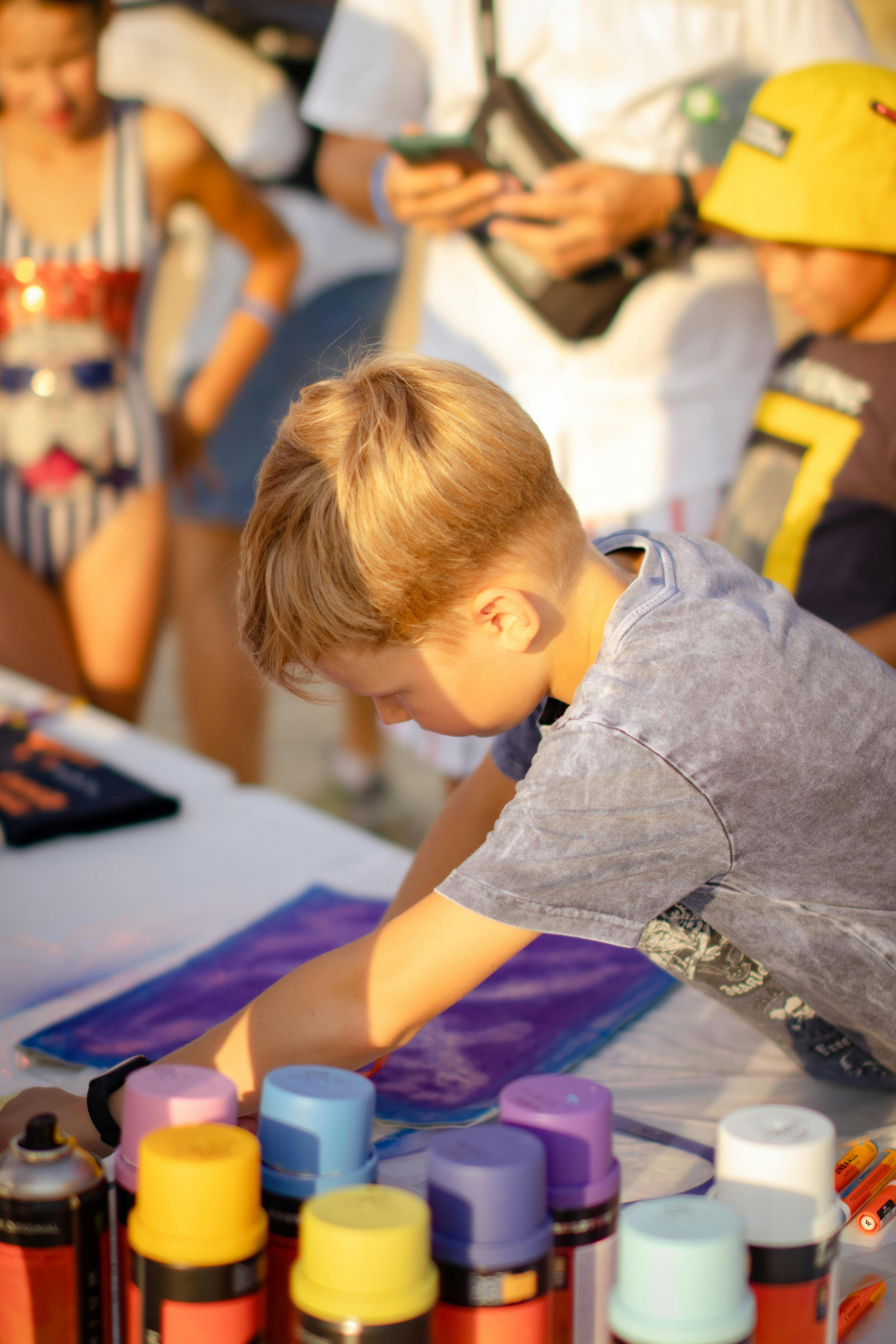 Little Boy Painting with Spray Bottles · Free Stock Photo