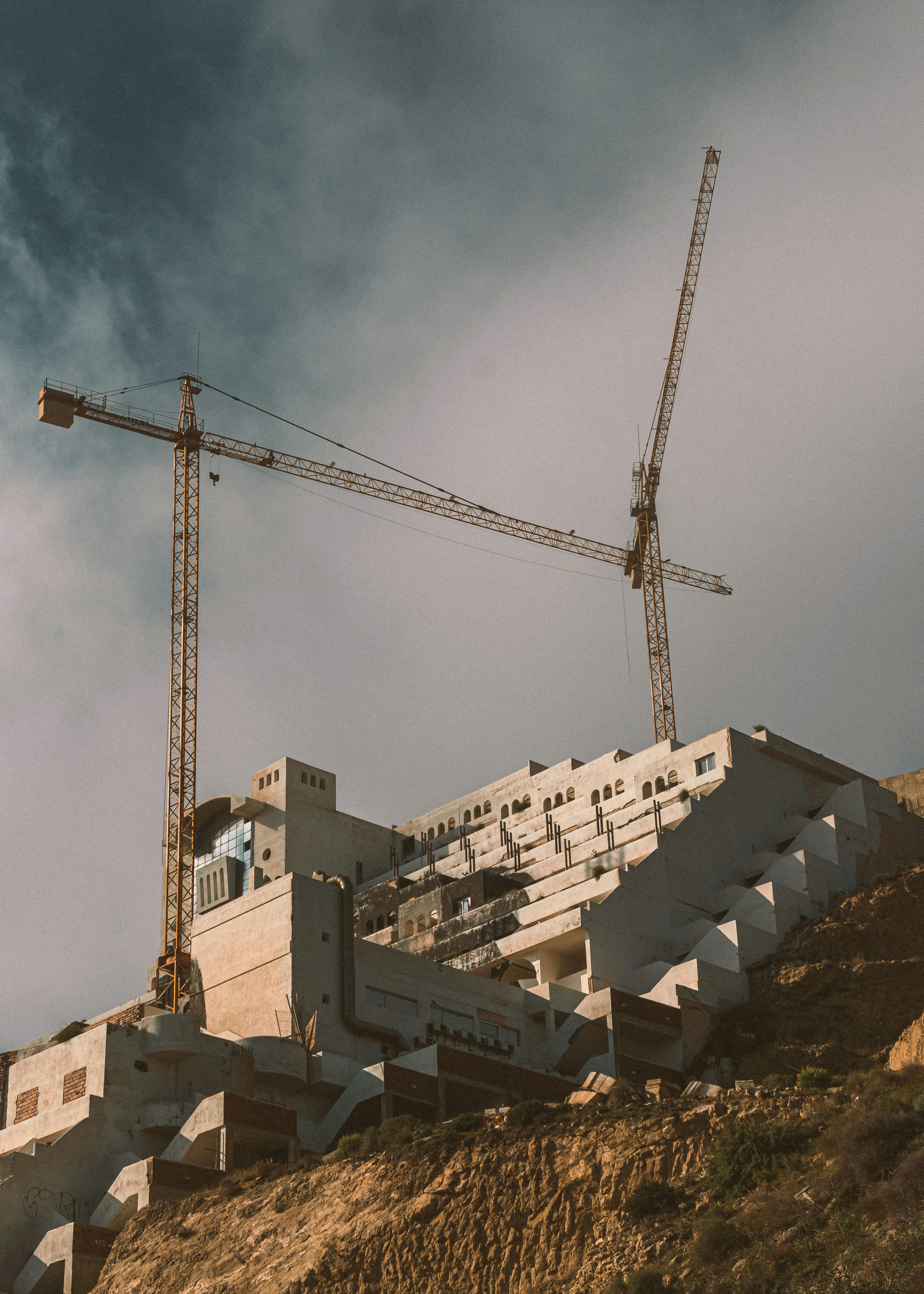 Modern Building and Cranes during Construction Work · Free Stock Photo