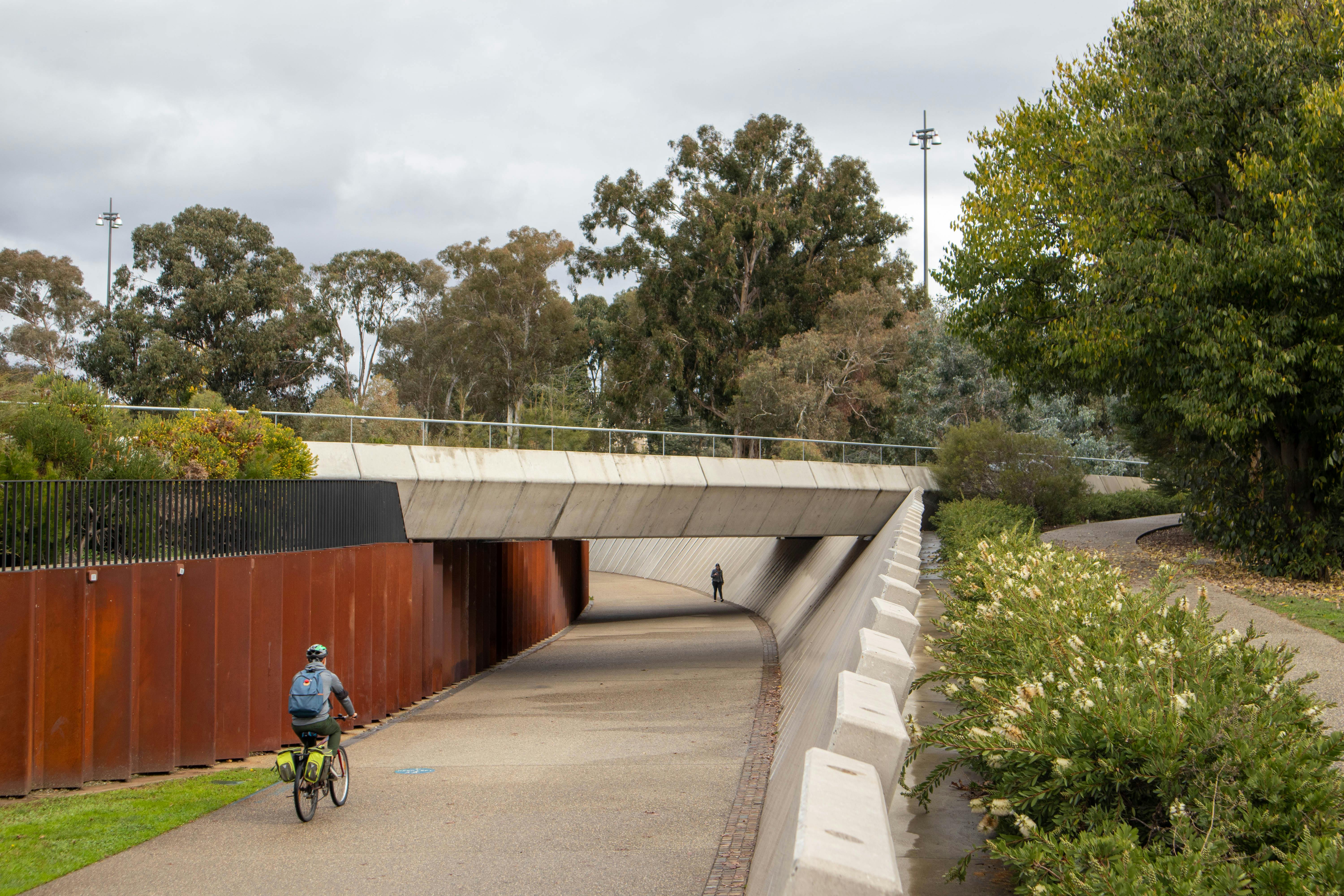 Cyclist Riding Under Overpass in Park · Free Stock Photo