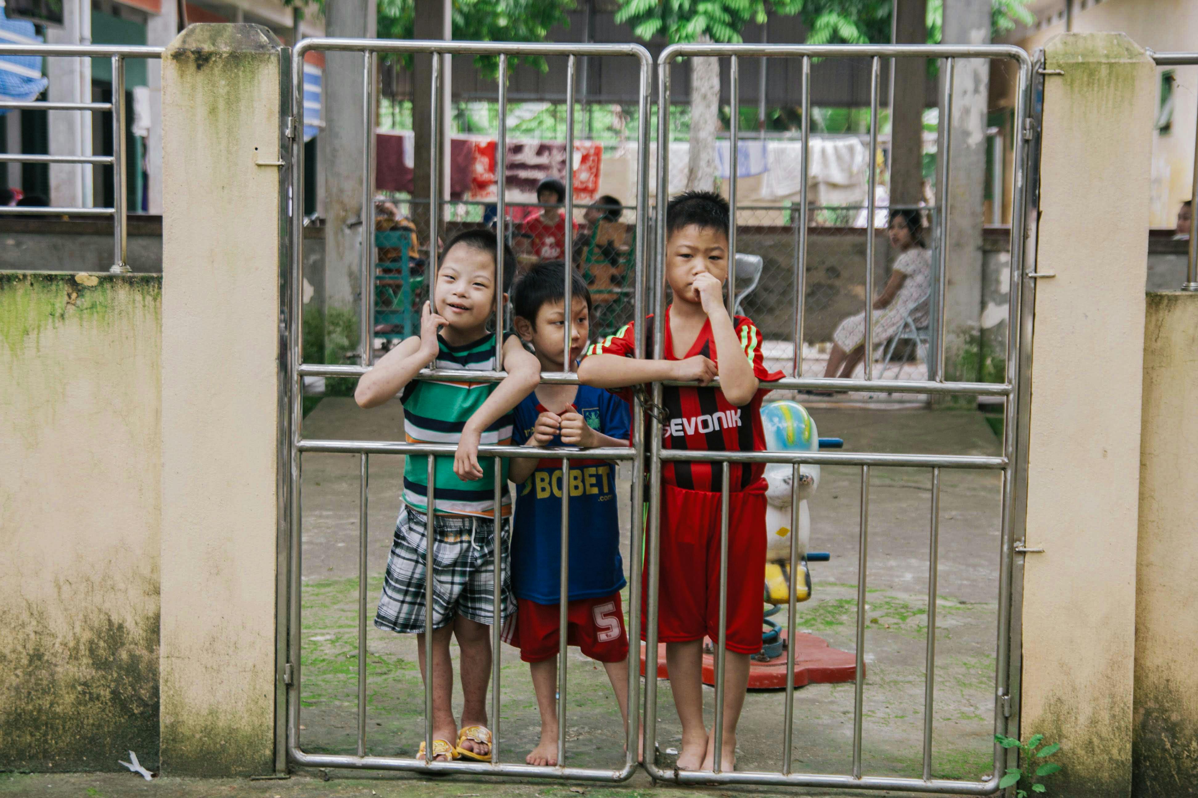 Kids Standing Beside the Metal Gate · Free Stock Photo