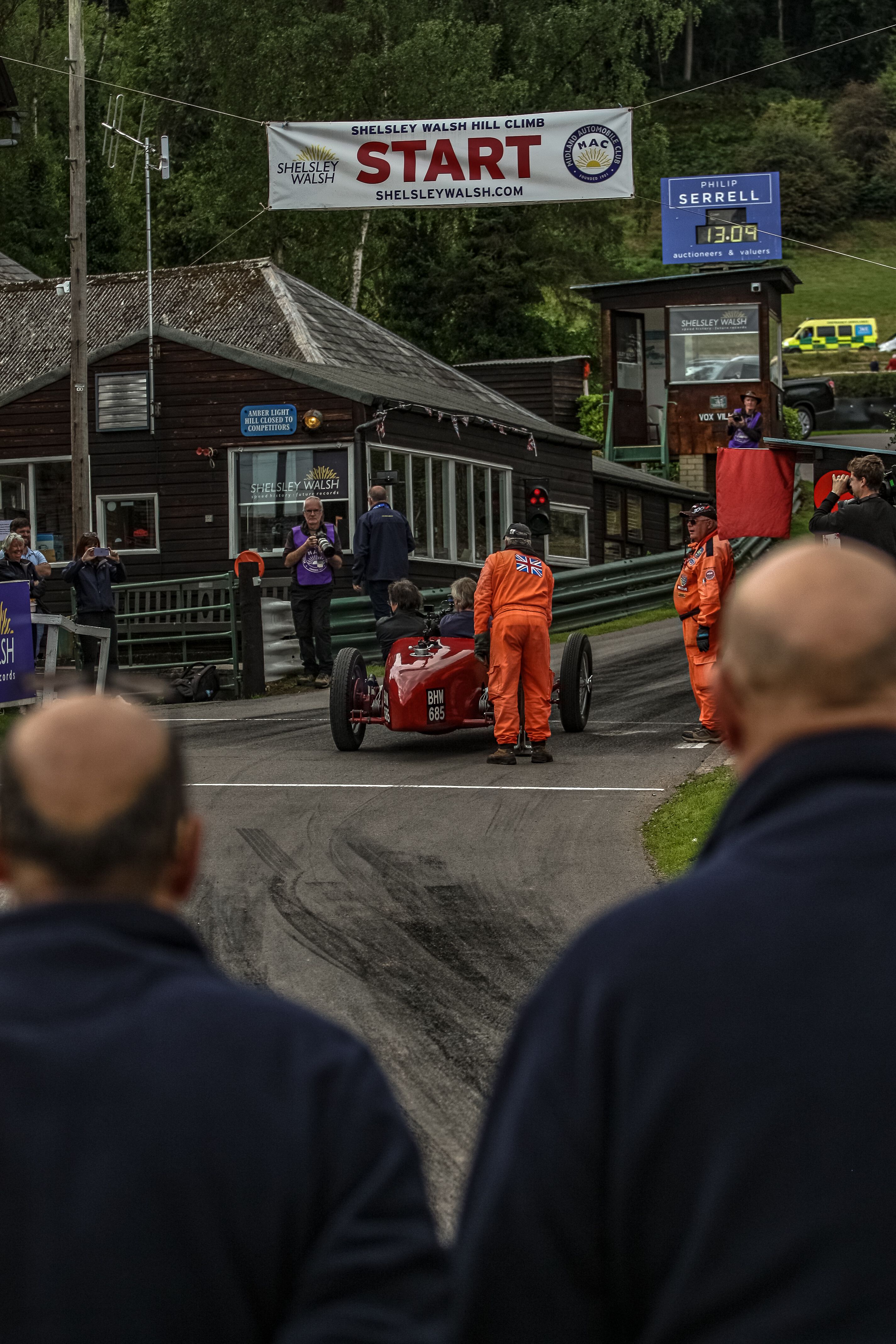 A Man in Orange Suit Standing in Front of the Racing Car · Free Stock Photo