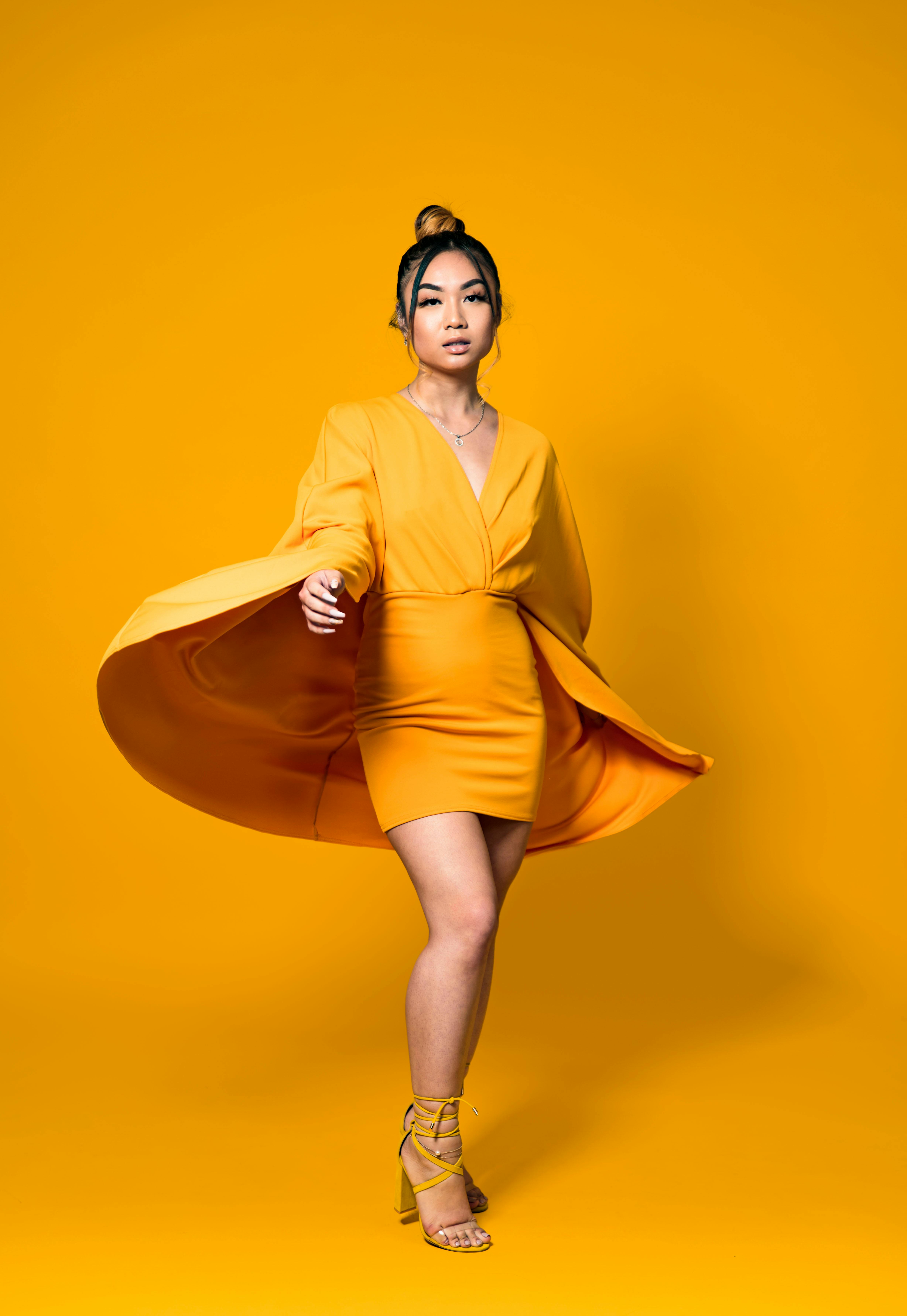 Woman in Yellow Dress Standing Near White Curtains · Free Stock Photo