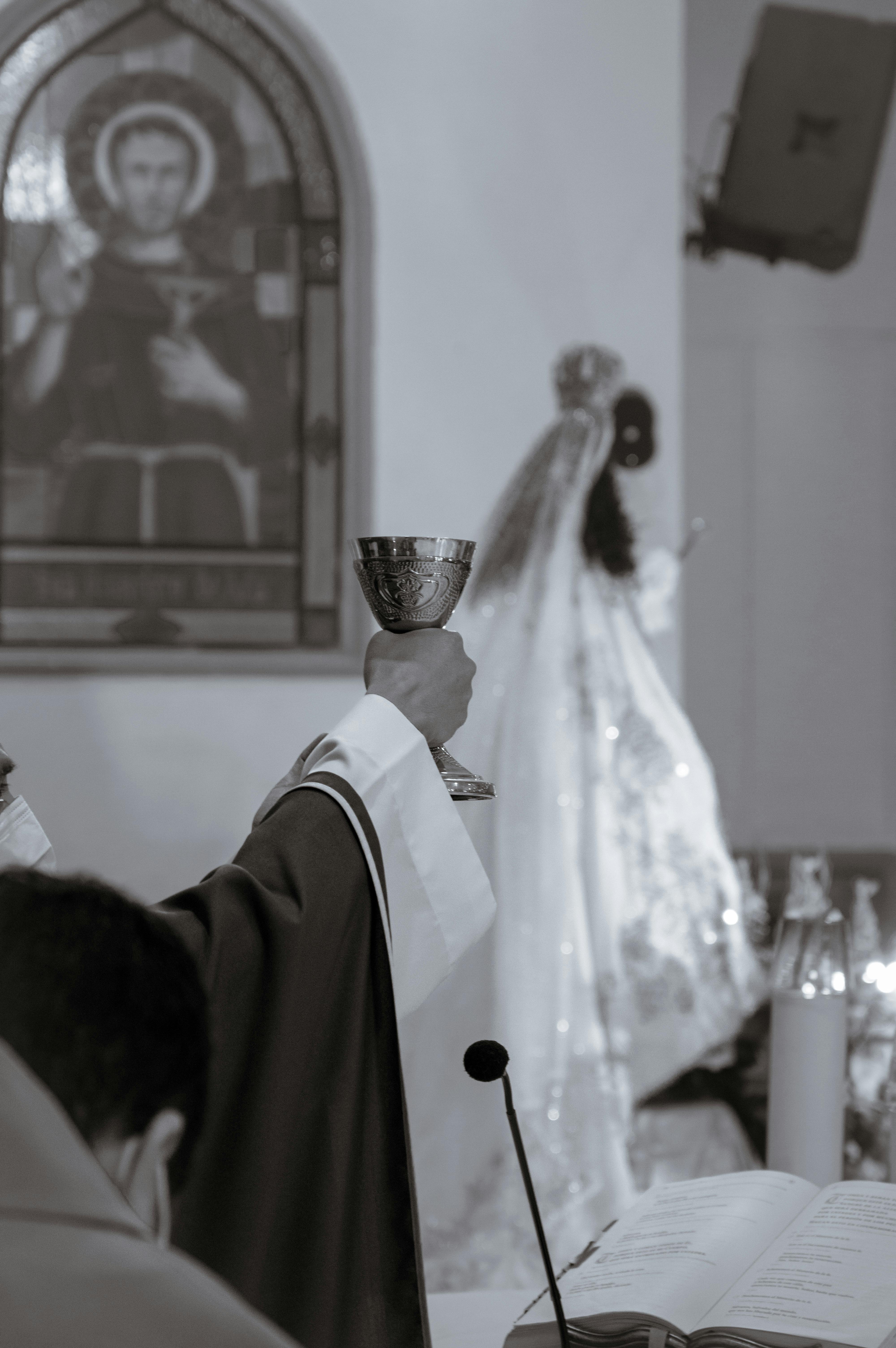 Priest Holding A Chalice and Communion Bread · Free Stock Photo
