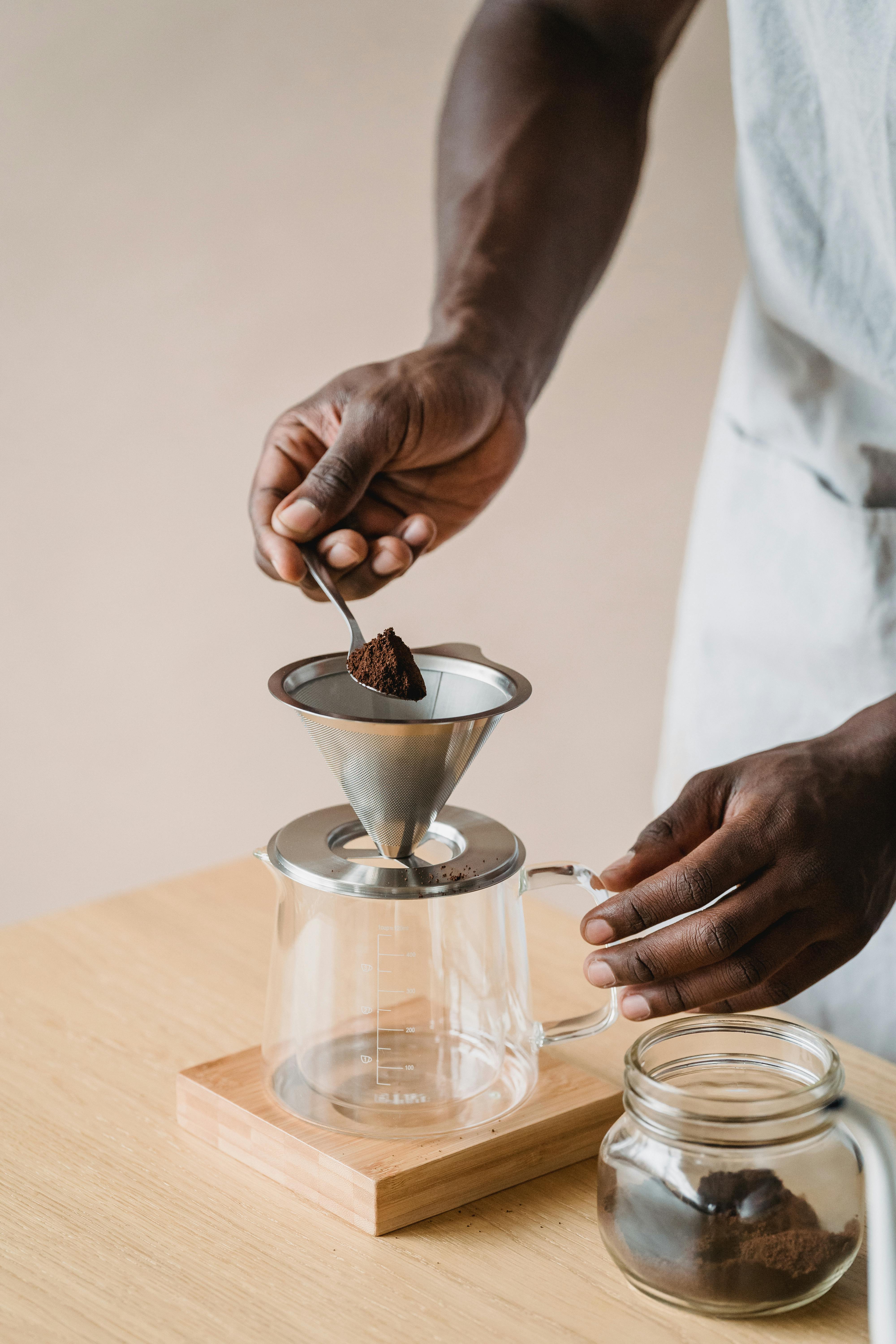 Man Sipping Coffee to Jar through Sieve · Free Stock Photo