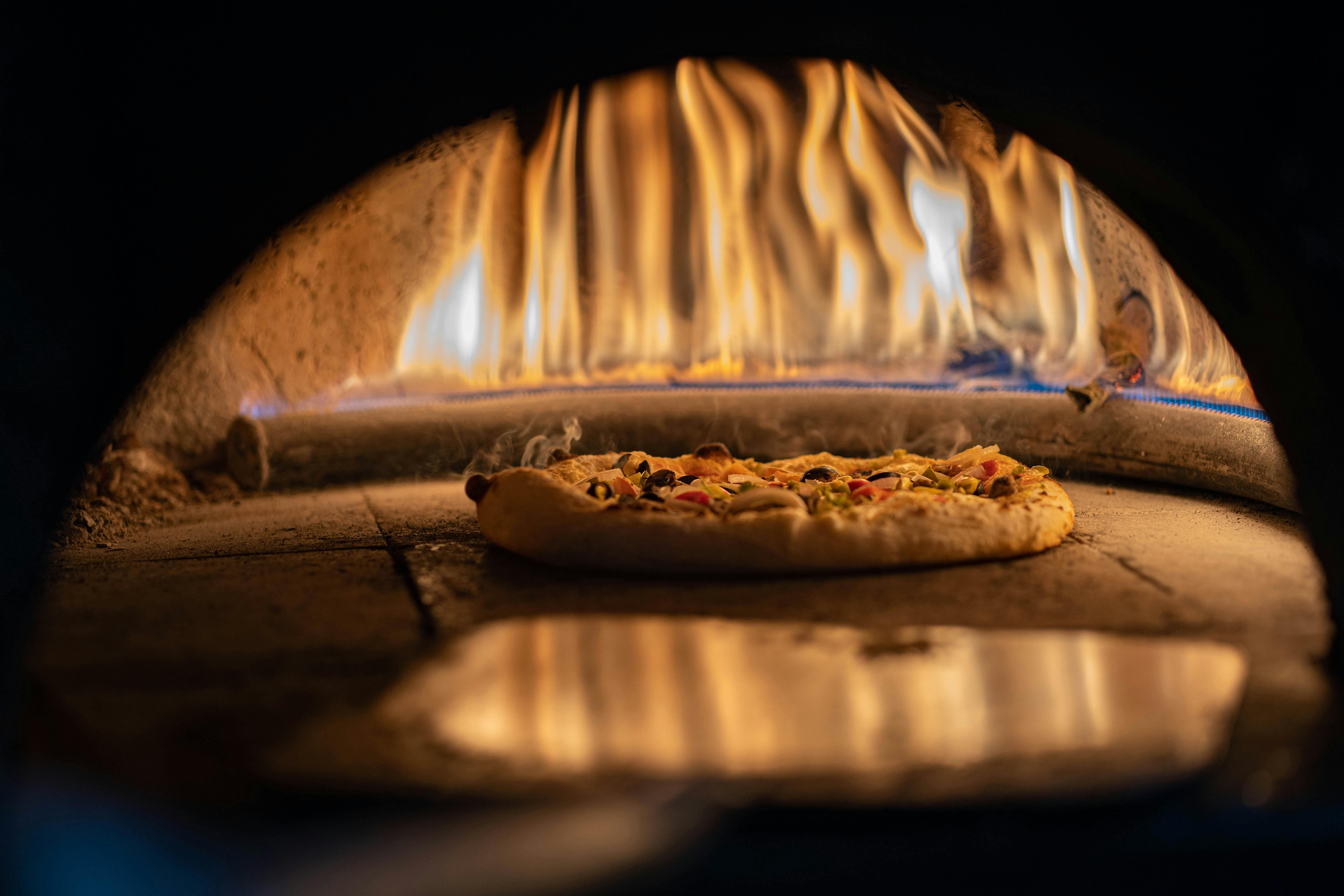 Pizza Baking in a Fire Oven · Free Stock Photo