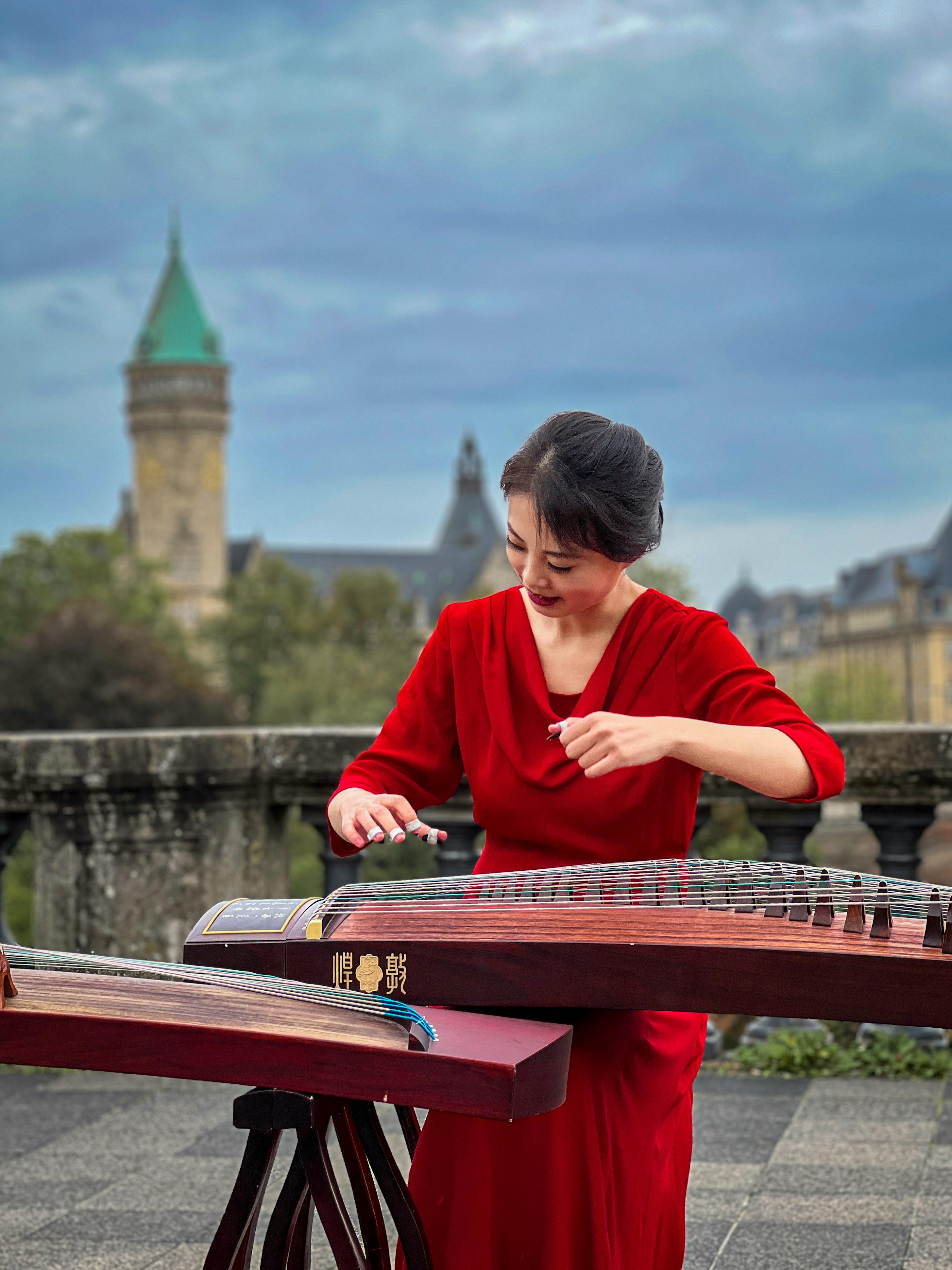 A Woman in Red Dress Playing Stringed Instrument · Free Stock Photo