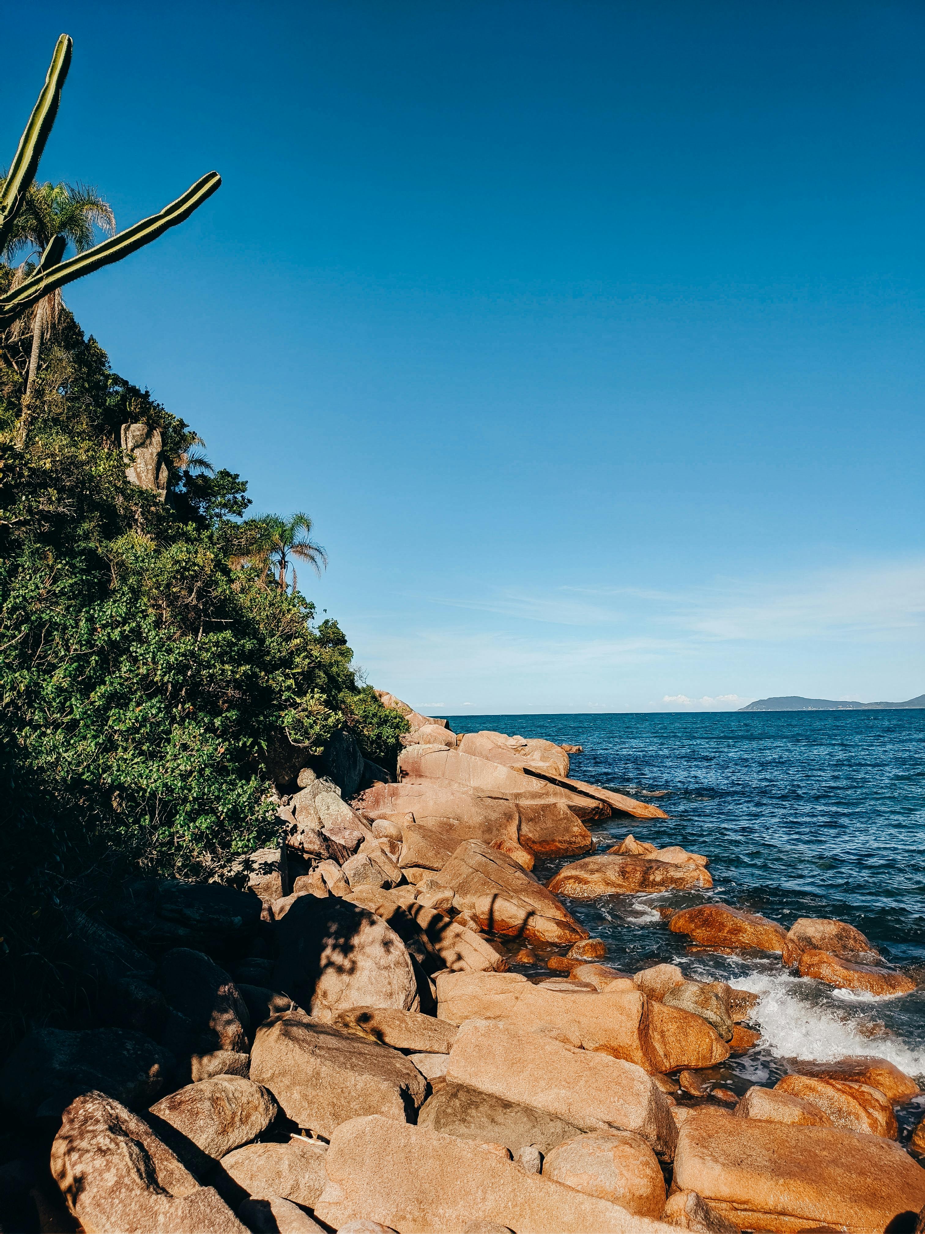 A Cliff Beside the Sea Under Blue Sky · Free Stock Photo
