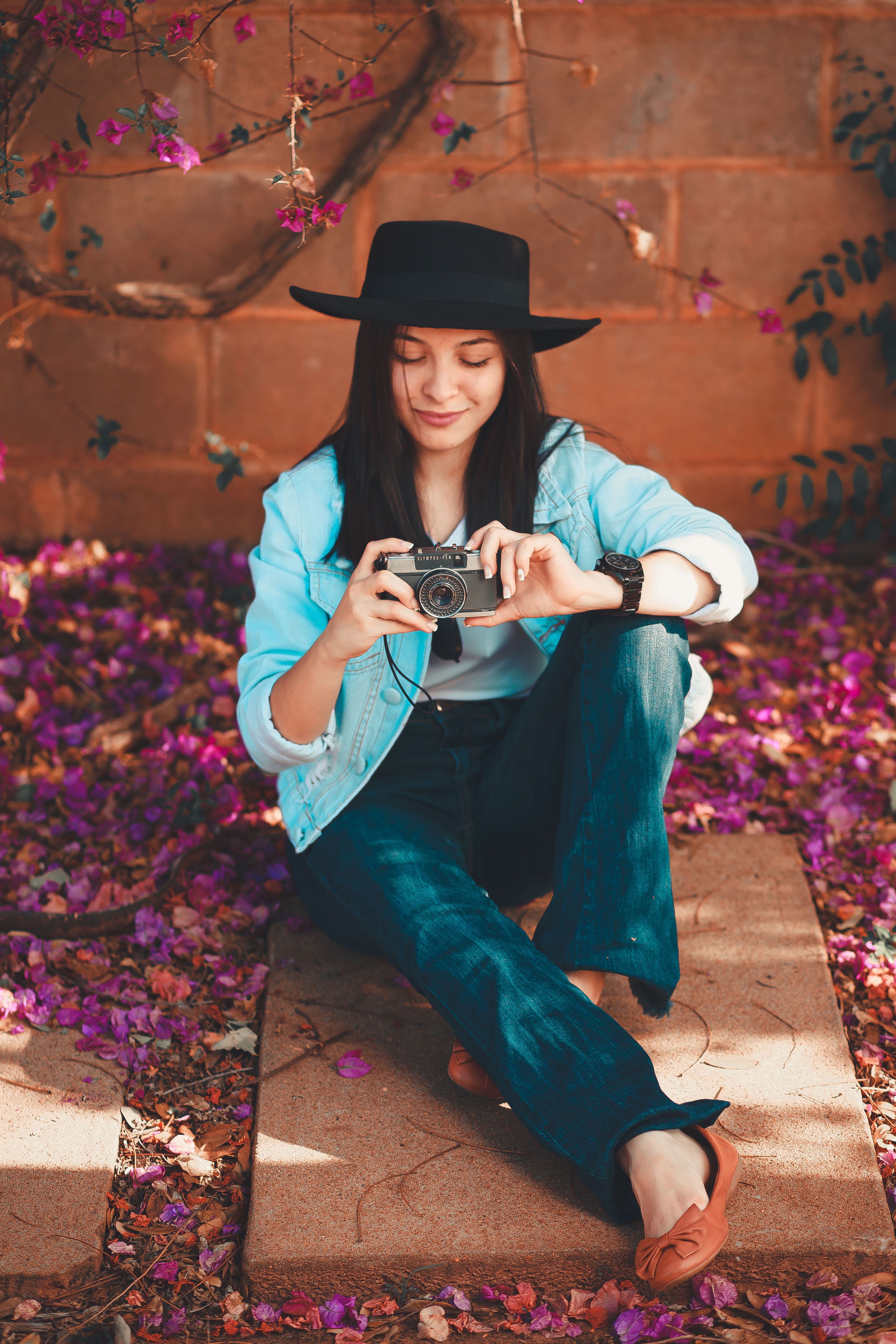 Smiling Woman Sitting with Camera · Free Stock Photo