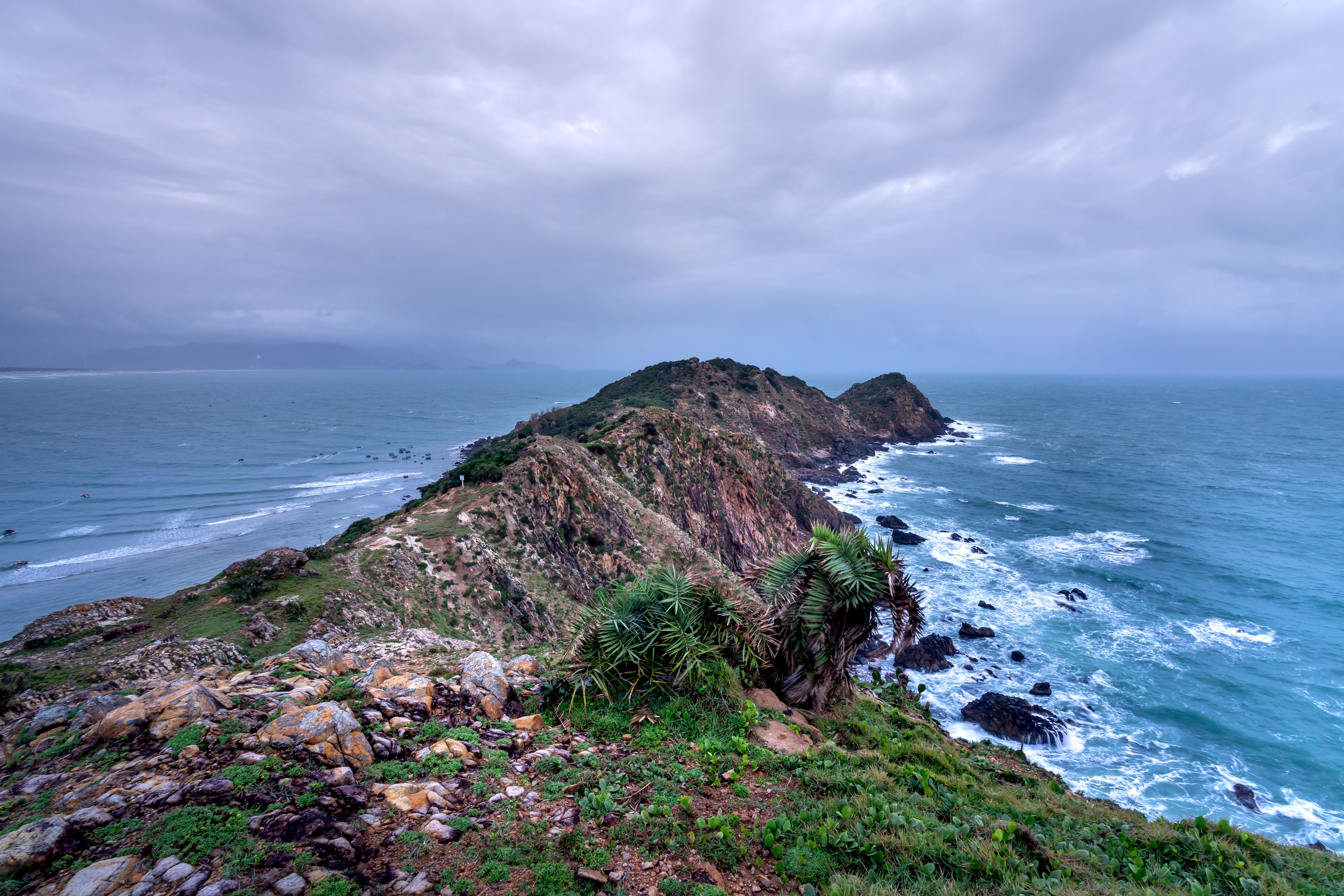 A Mountain Between Ocean Under the Cloudy Sky · Free Stock Photo