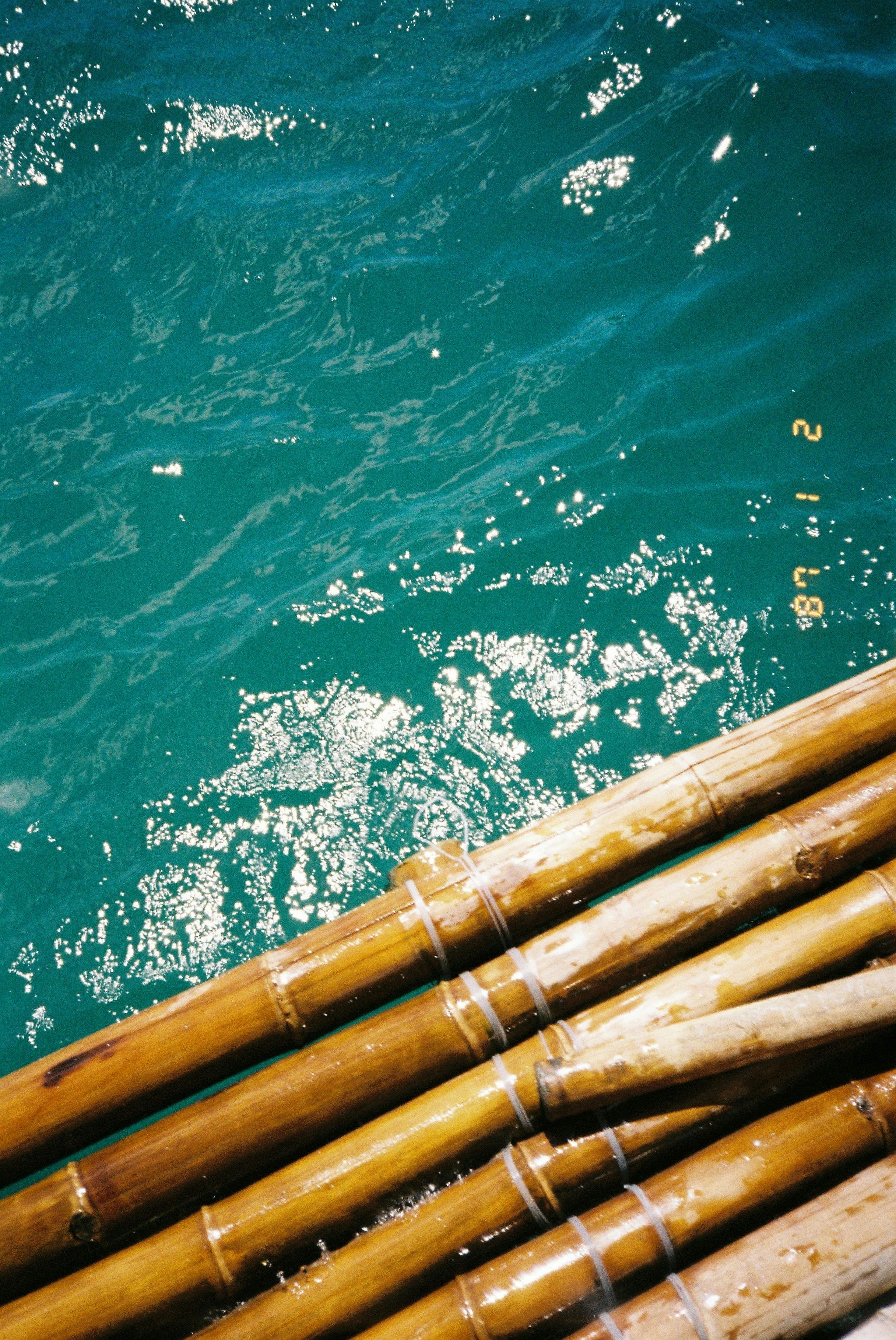 A Naked Person Under a Wooden Plank on a Bamboo Raft · Free Stock Photo