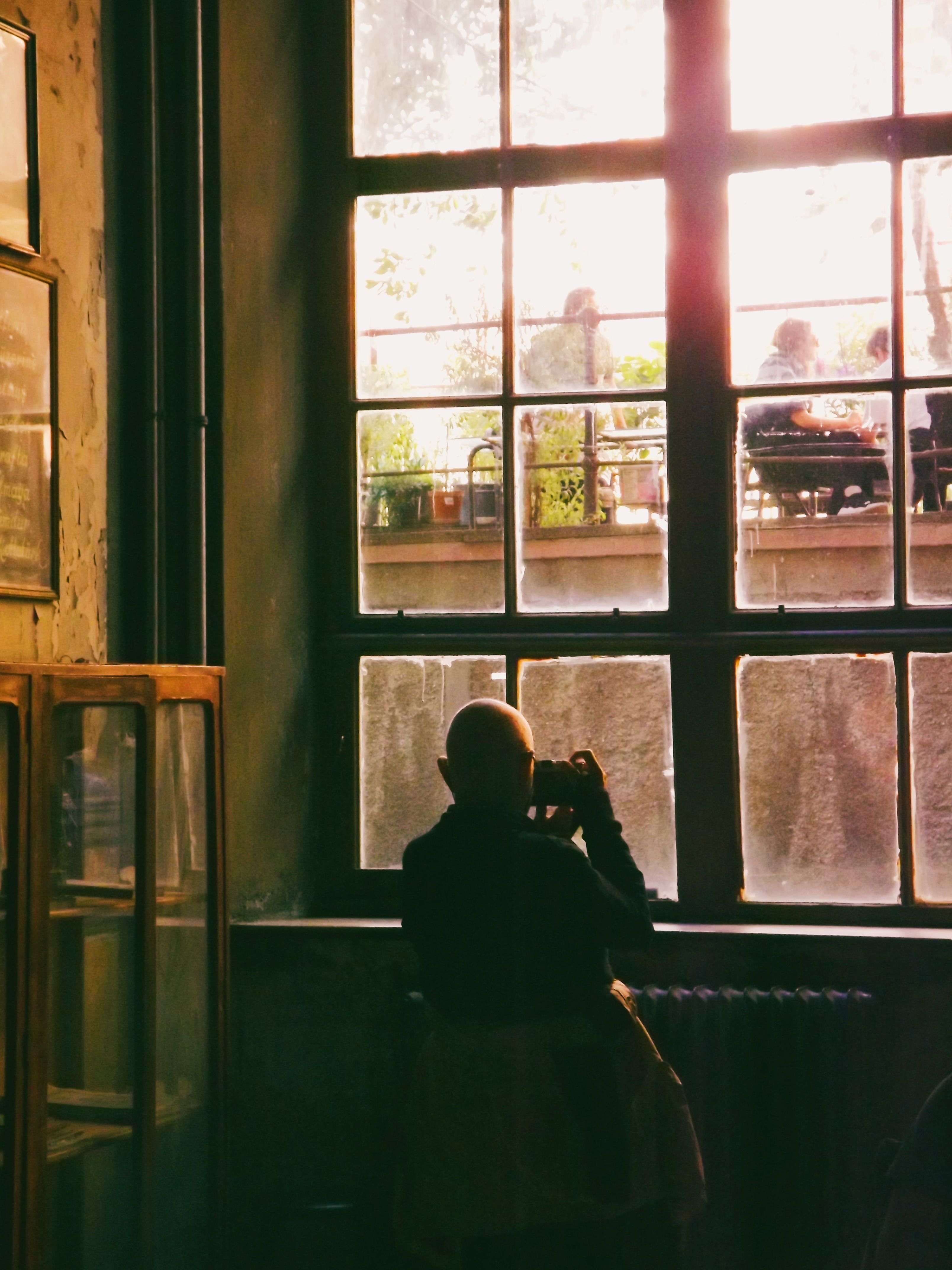 Back View of Person Taking Photos Near the Glass Window · Free Stock Photo