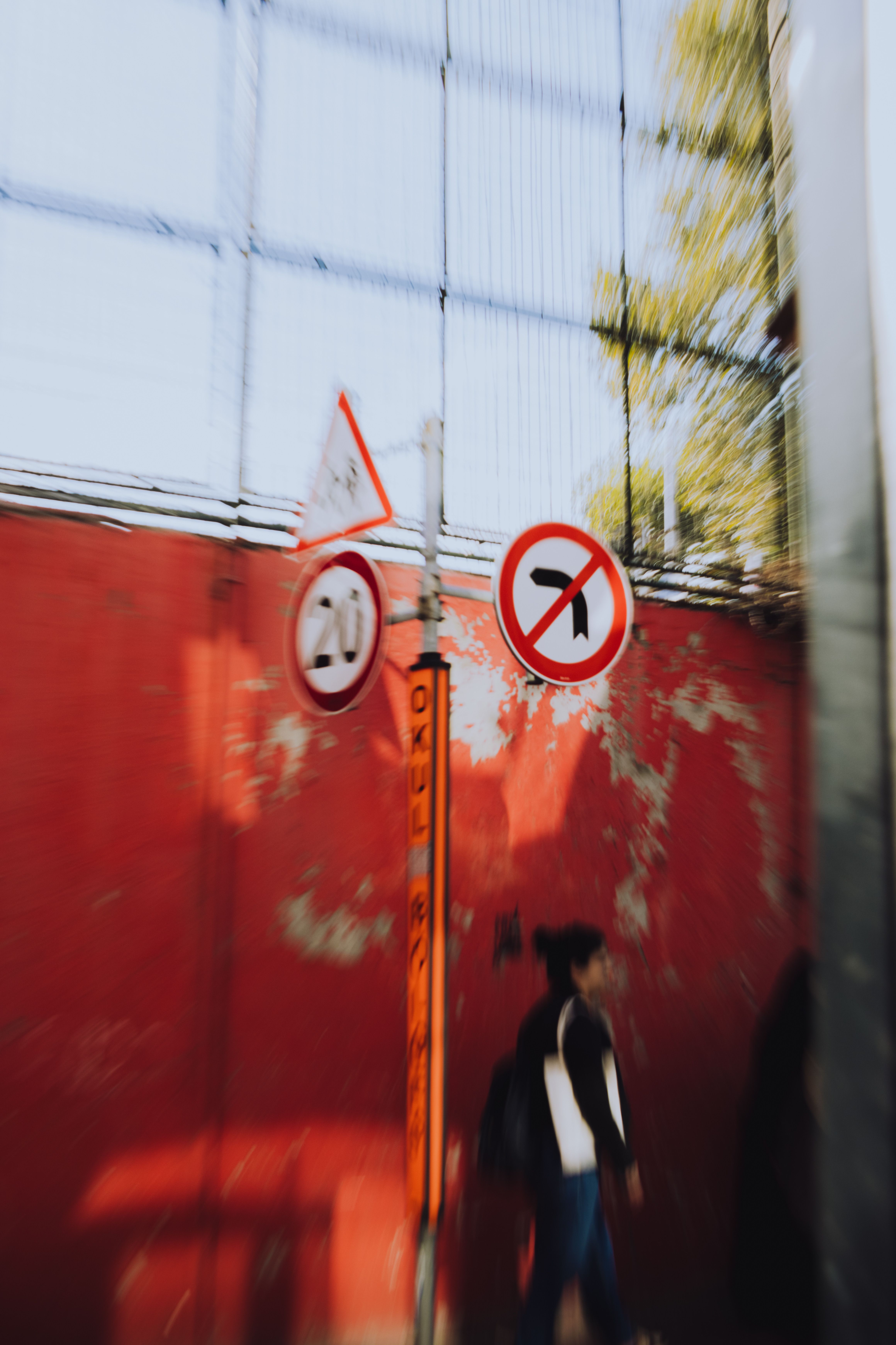 Road Signs Near the Red Metal Gate · Free Stock Photo