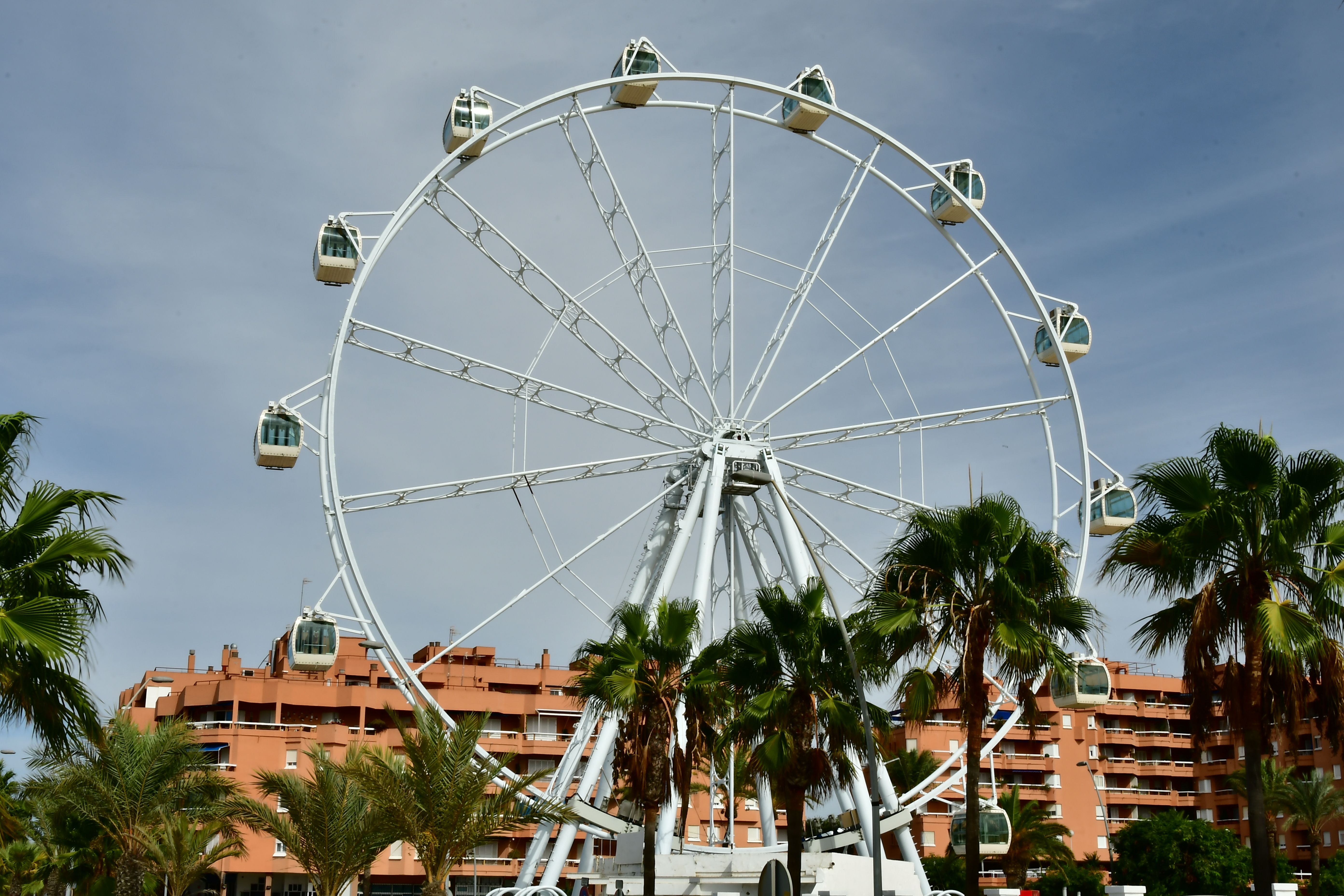 A White Ferris Wheel Near a Concrete Building · Free Stock Photo