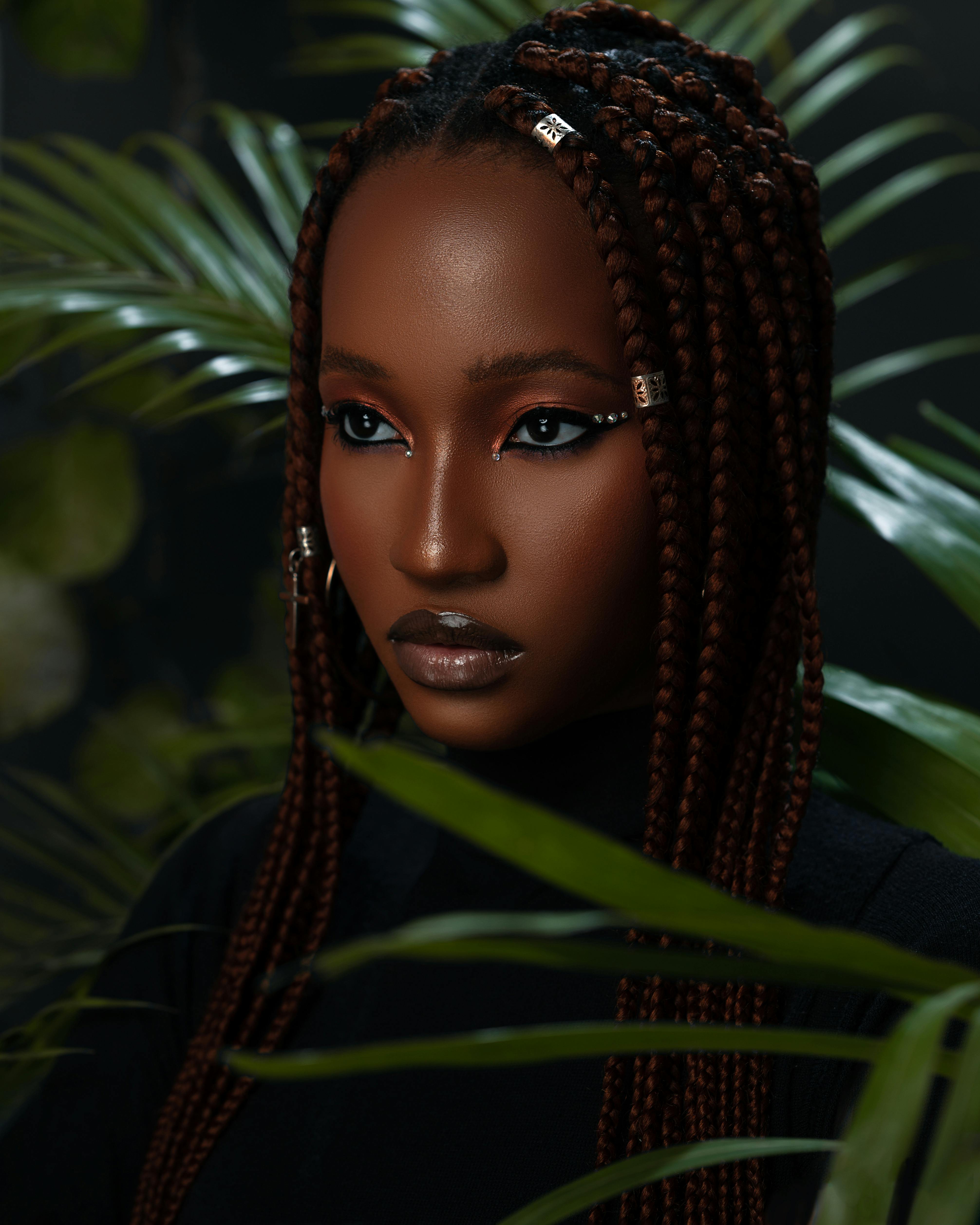 Portrait of Woman with Box Braids among Leaves · Free Stock Photo