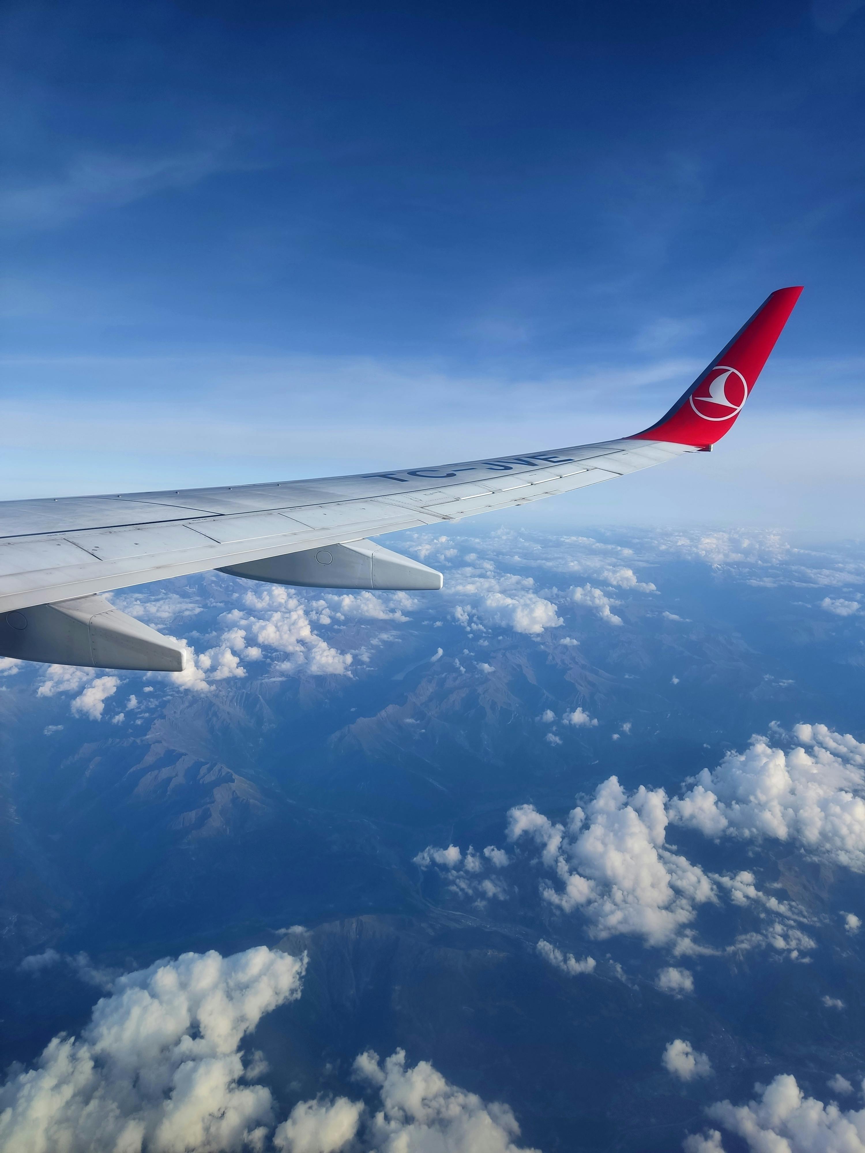 White and Red Airplane Wing over White Clouds · Free Stock Photo