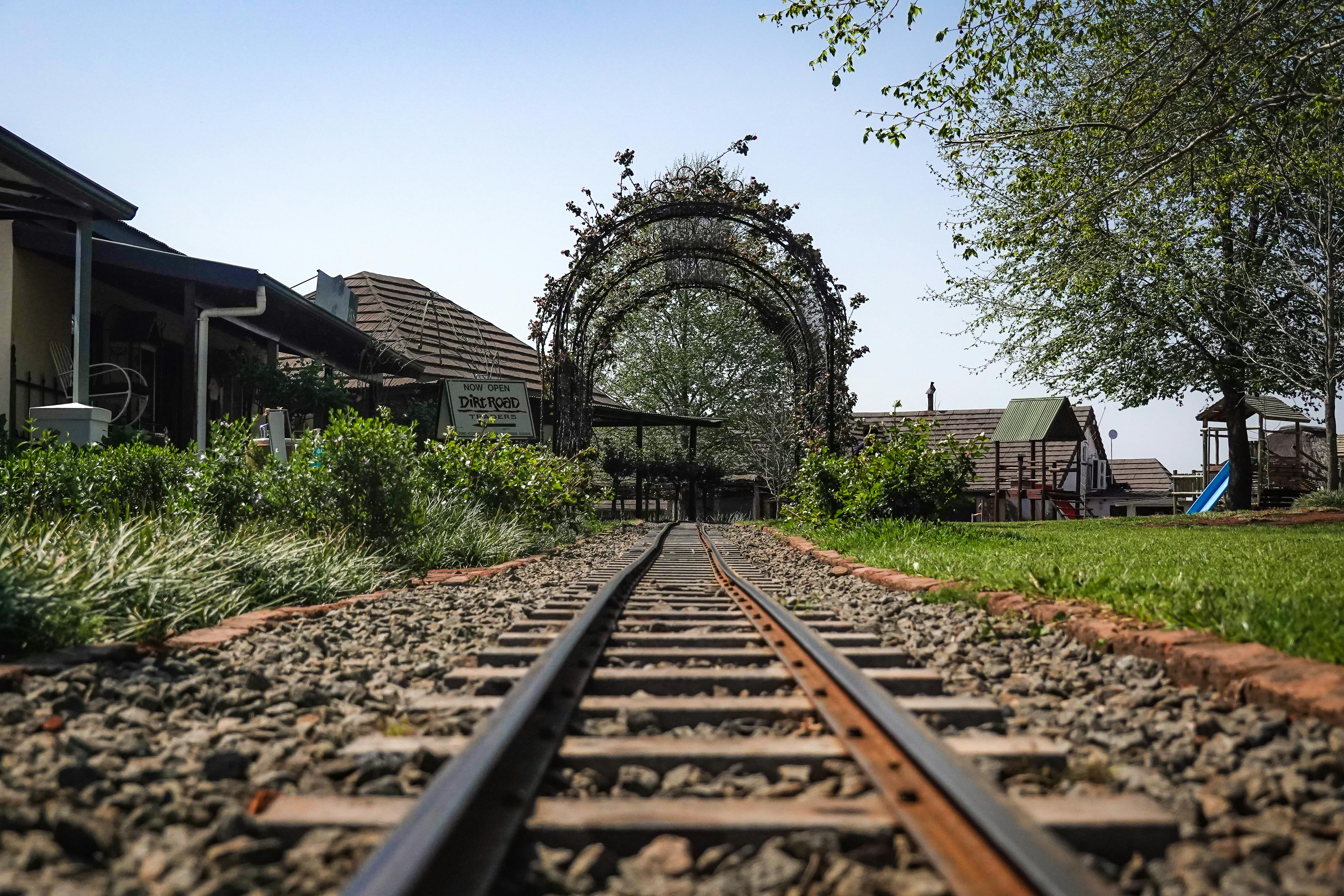 Railroad Tracks under Floral Arch · Free Stock Photo