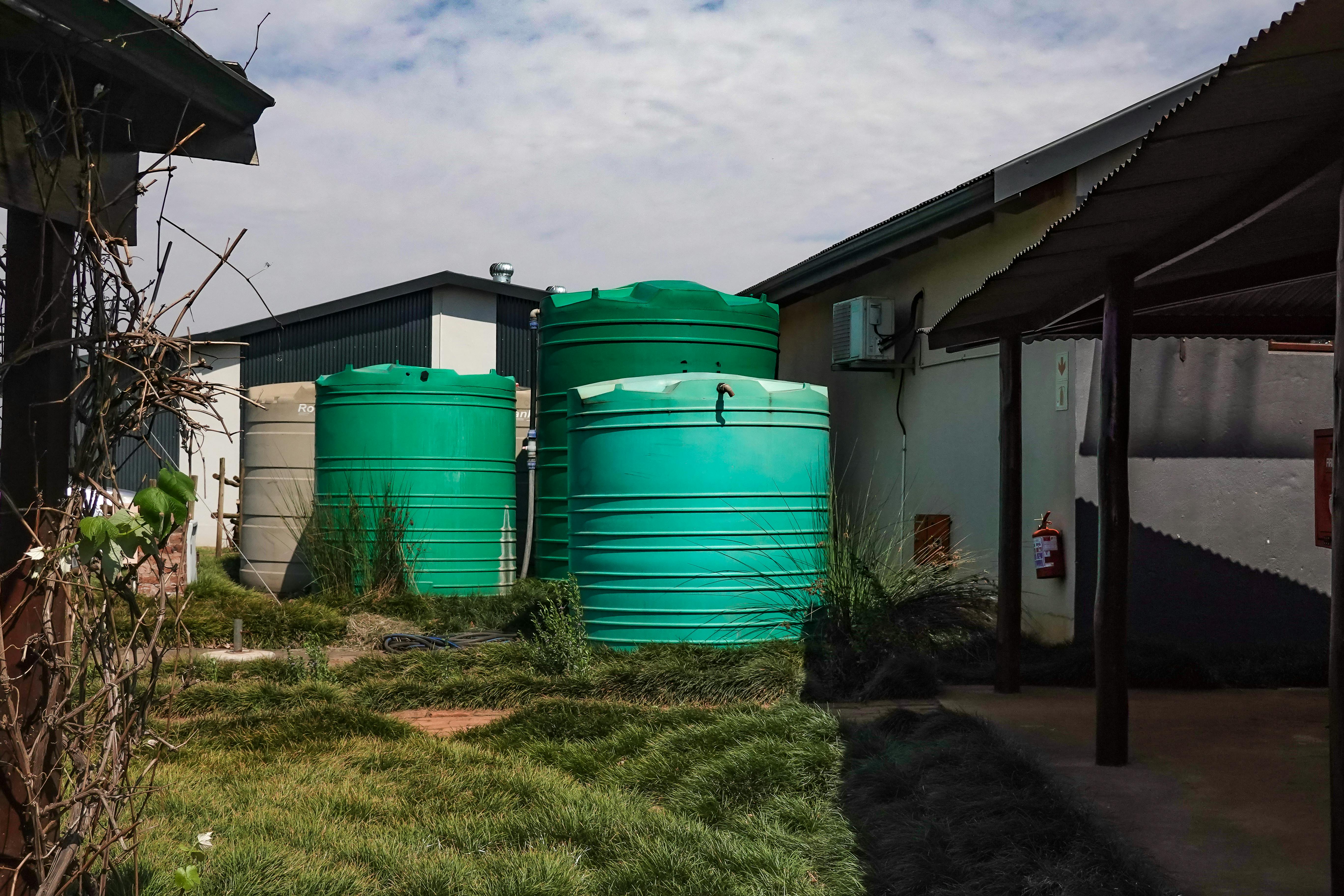 Large Containers Standing by the Building on a Farm · Free Stock Photo