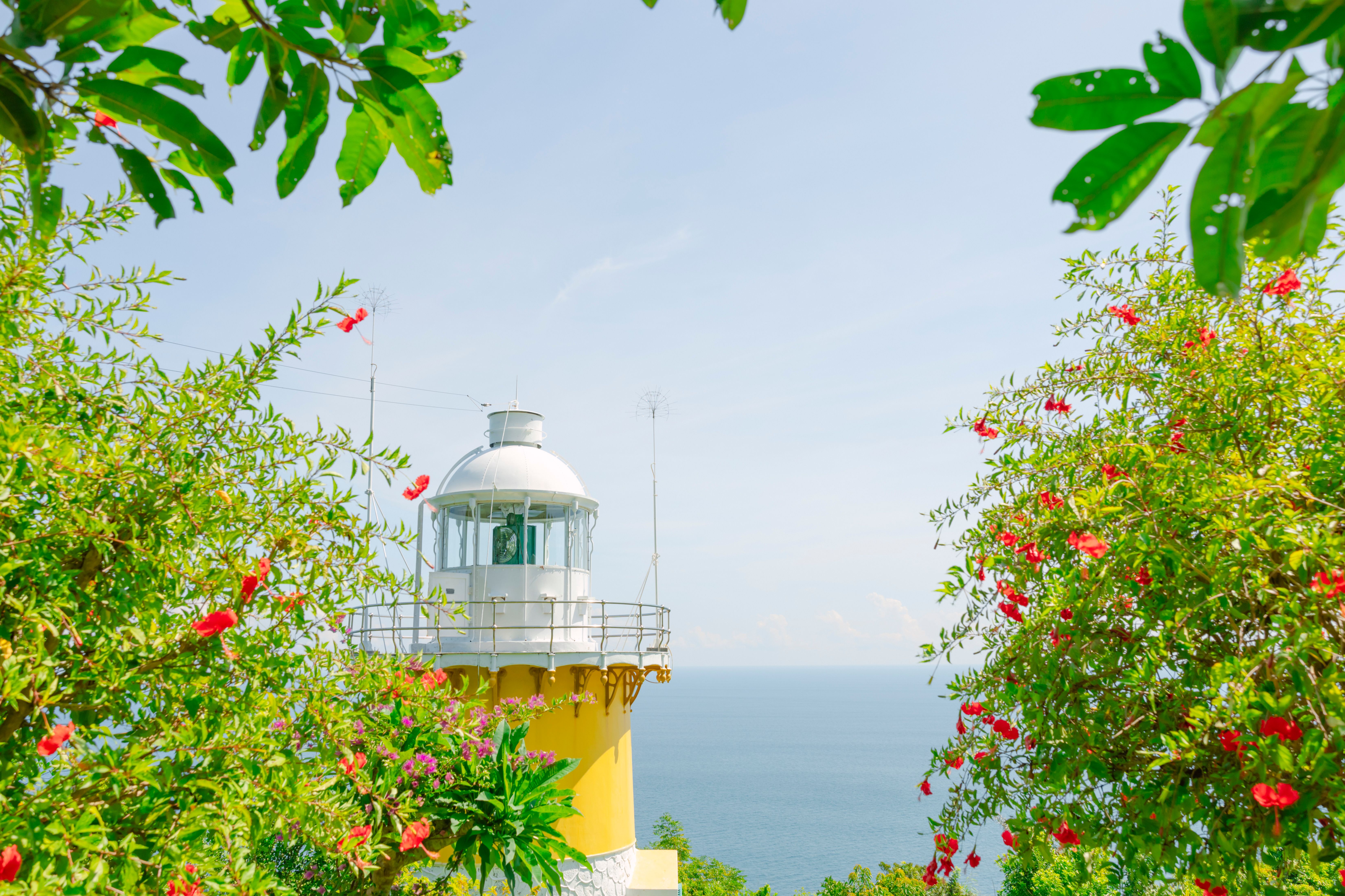 White and Yellow Lighthouse Near Body of Water · Free Stock Photo