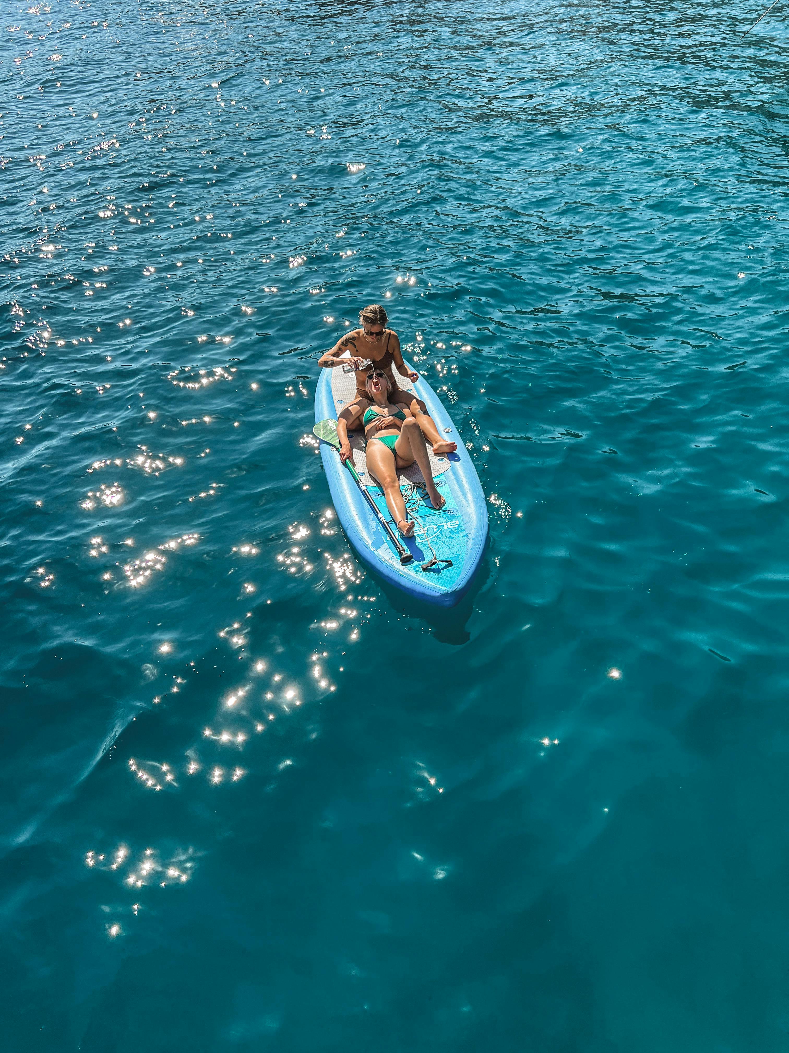 Top View of a Young Woman Lying in a Paddleboard on the Sea Surface ...