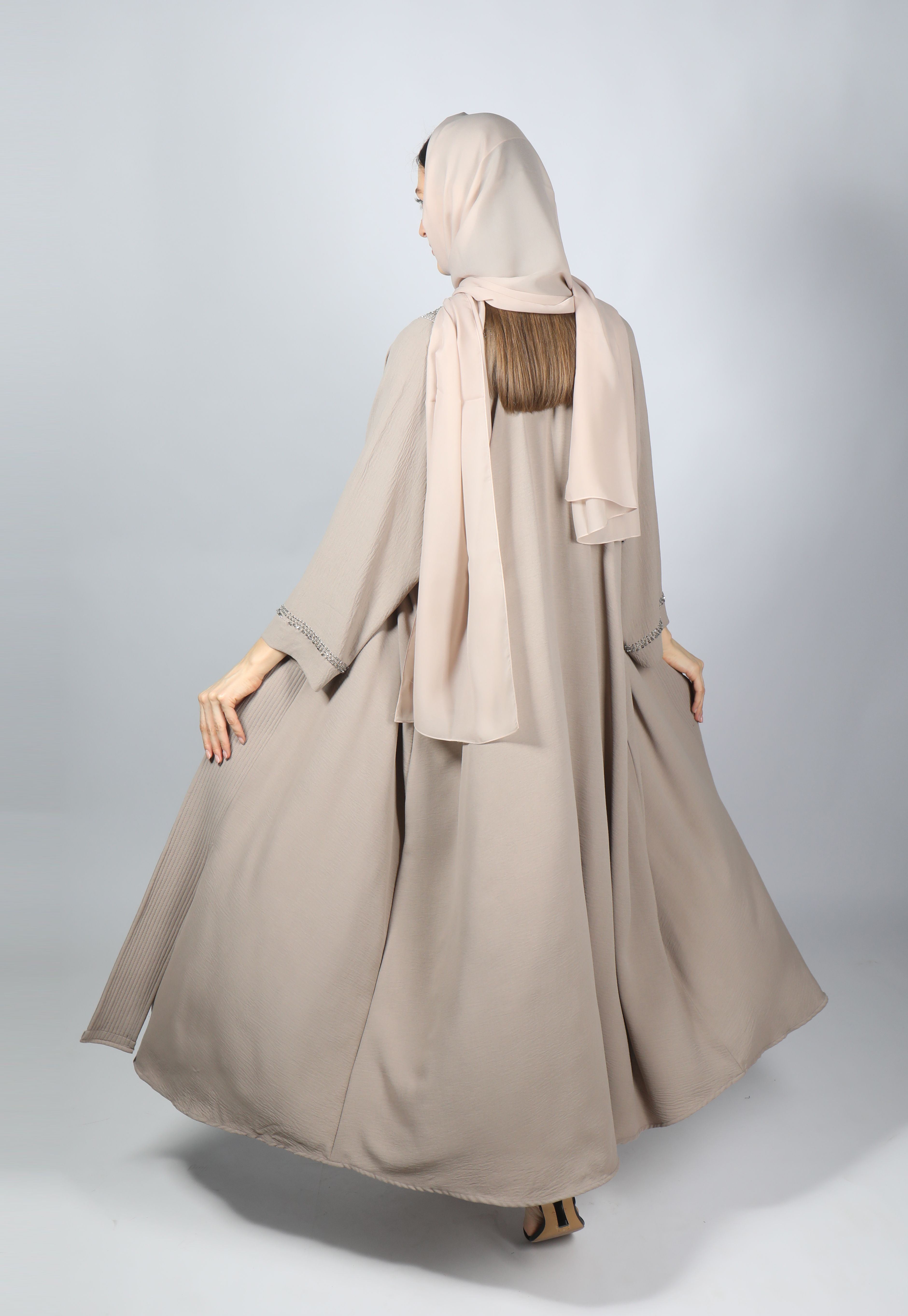Back View of a Woman Wearing a Beige Hijab and Abaya · Free Stock Photo