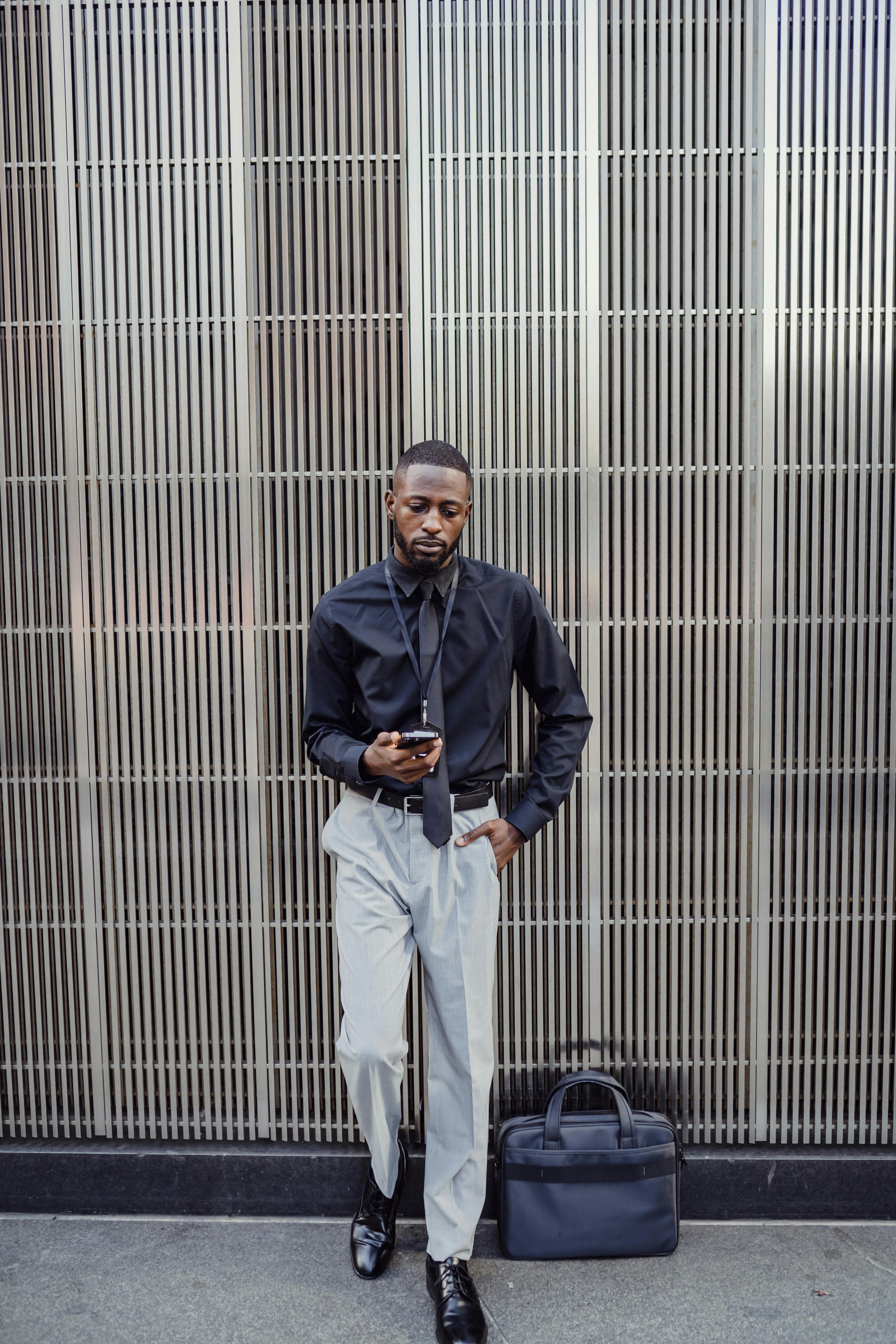 A Man Standing and Using his Phone · Free Stock Photo