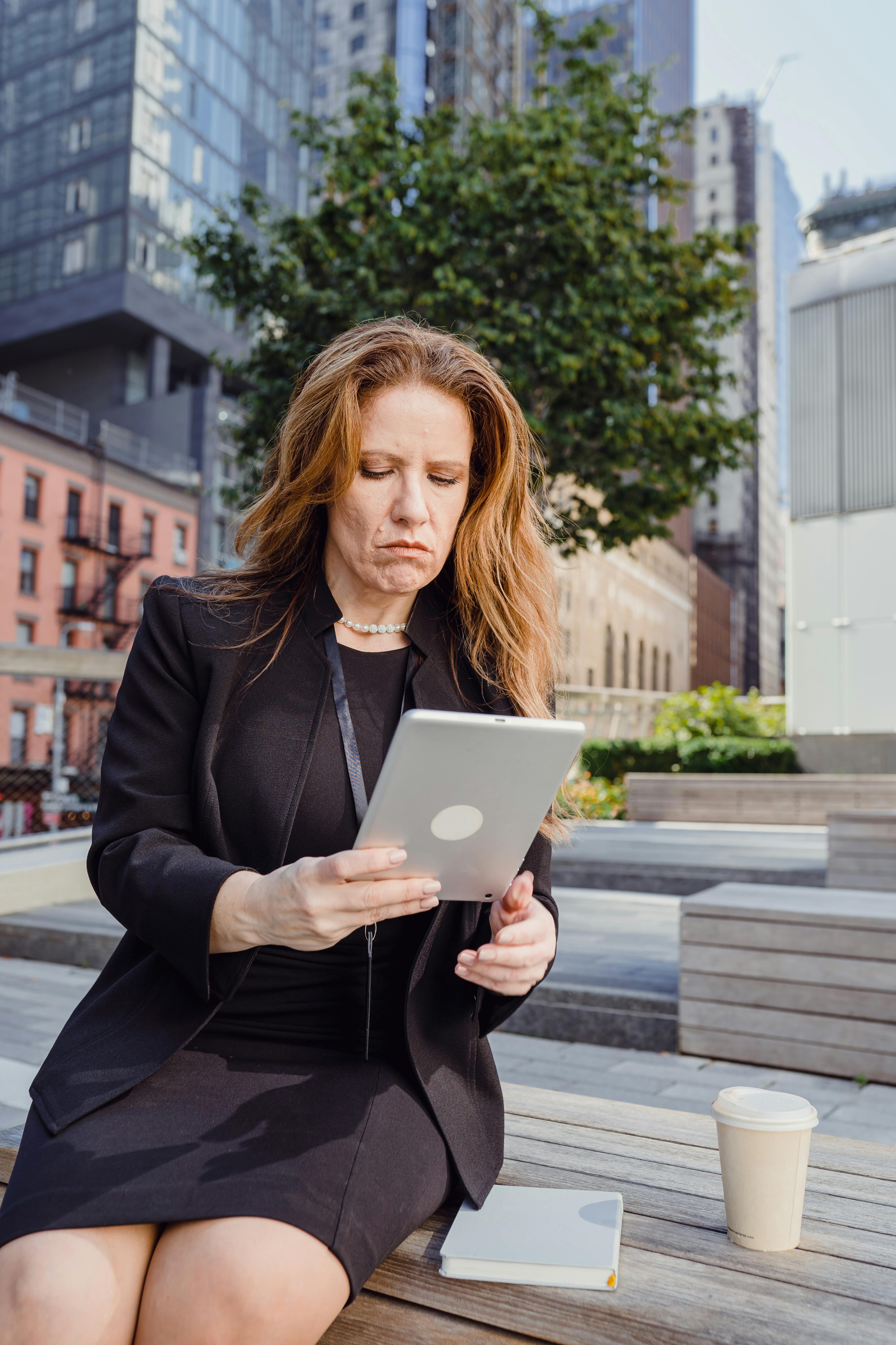 A Woman Sitting while Holding a Clipboard · Free Stock Photo