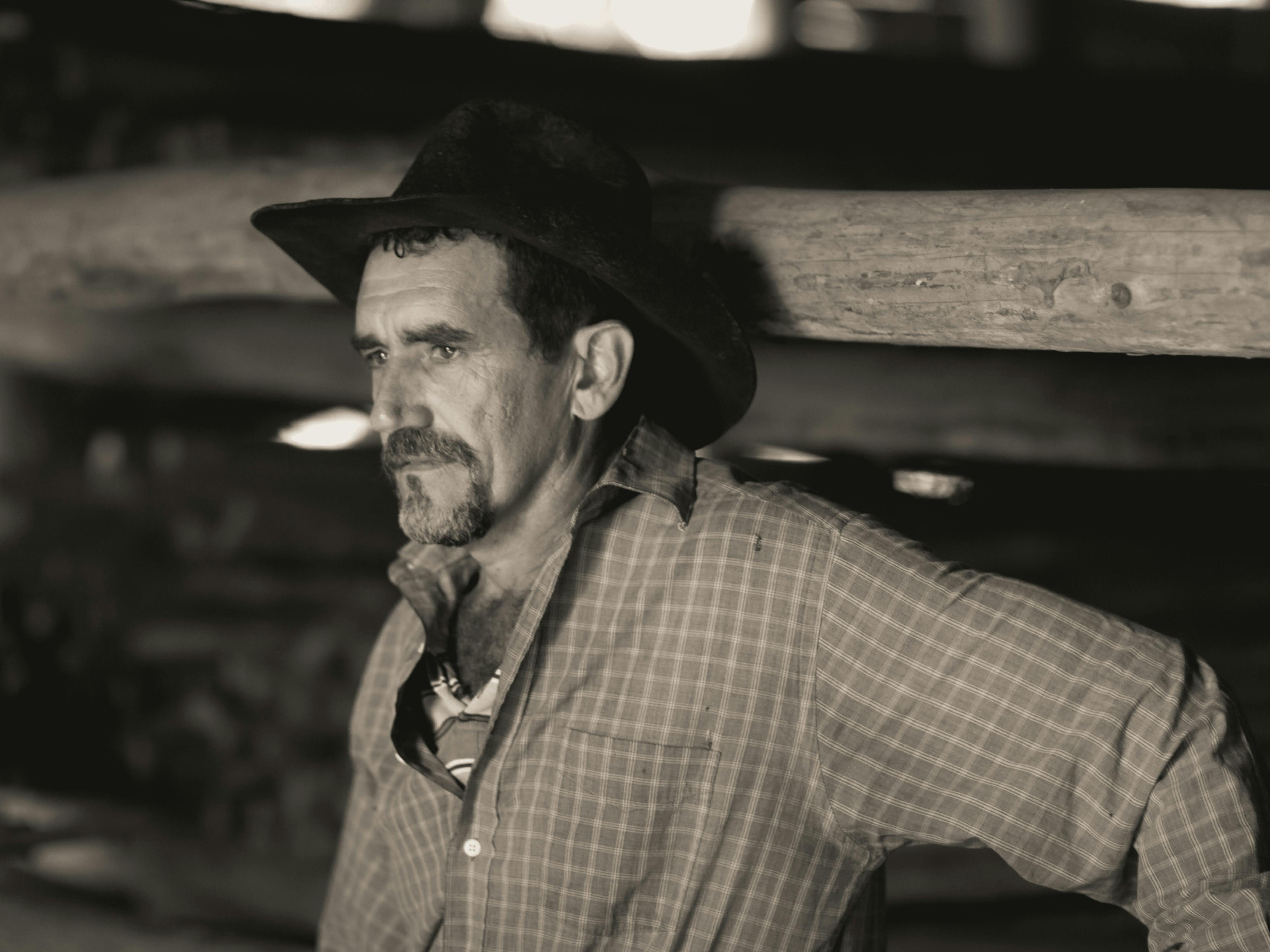 Photo of a Cowboy in a Pasture with a Rocky Mountain in the Background ...