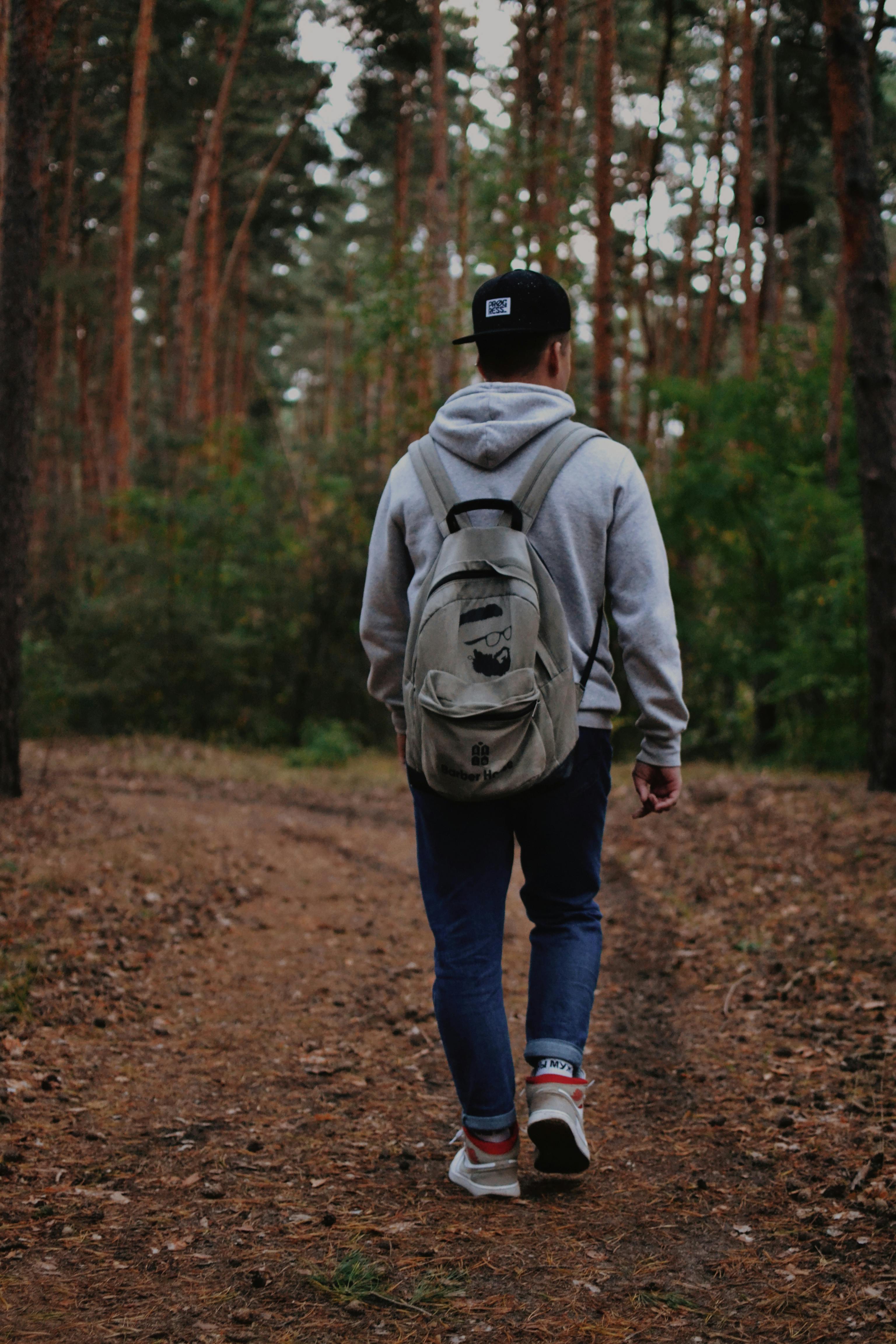 Man with Backpack Sitting in Forest · Free Stock Photo