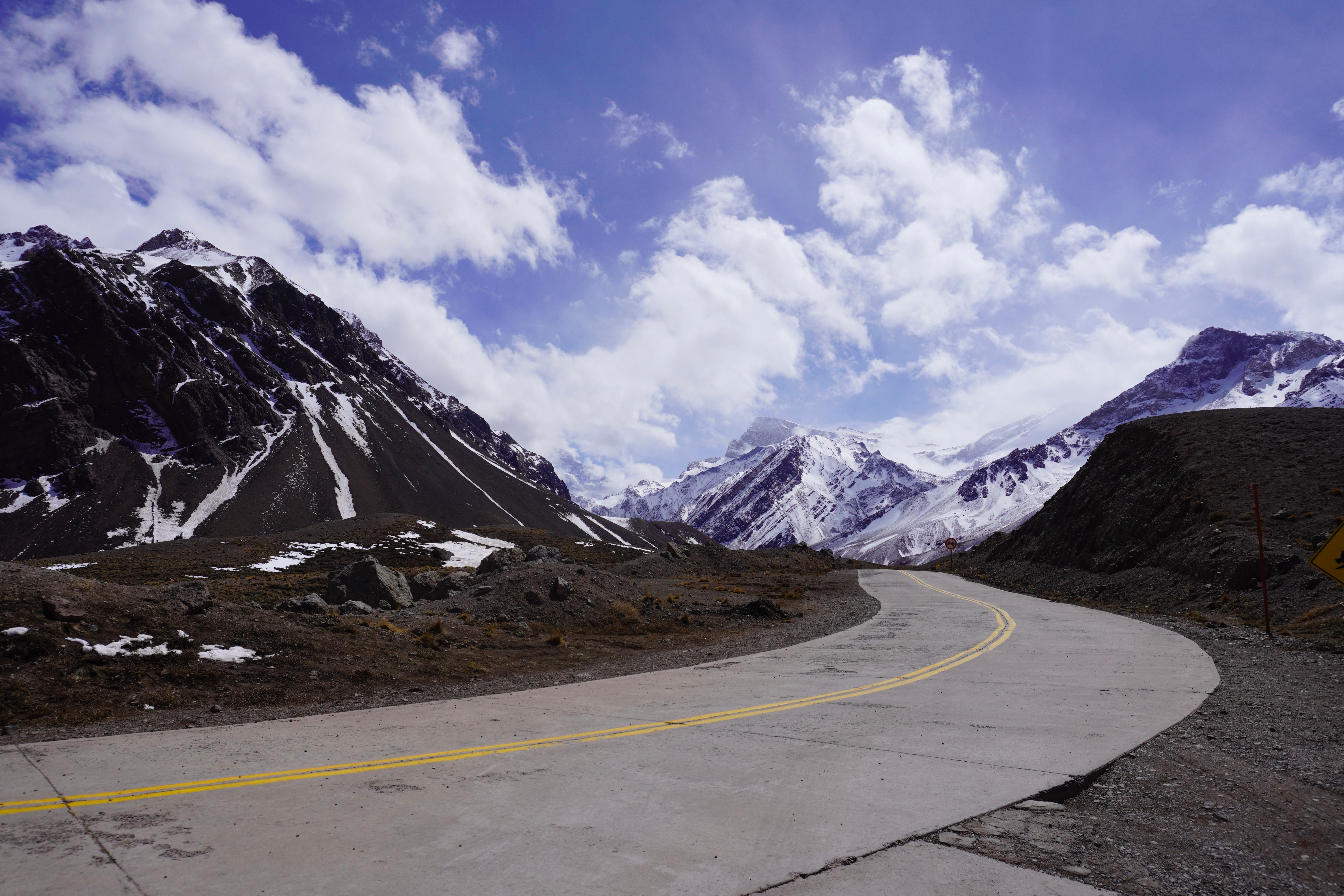 An Asphalt Road Between Snow Covered Mountains · Free Stock Photo