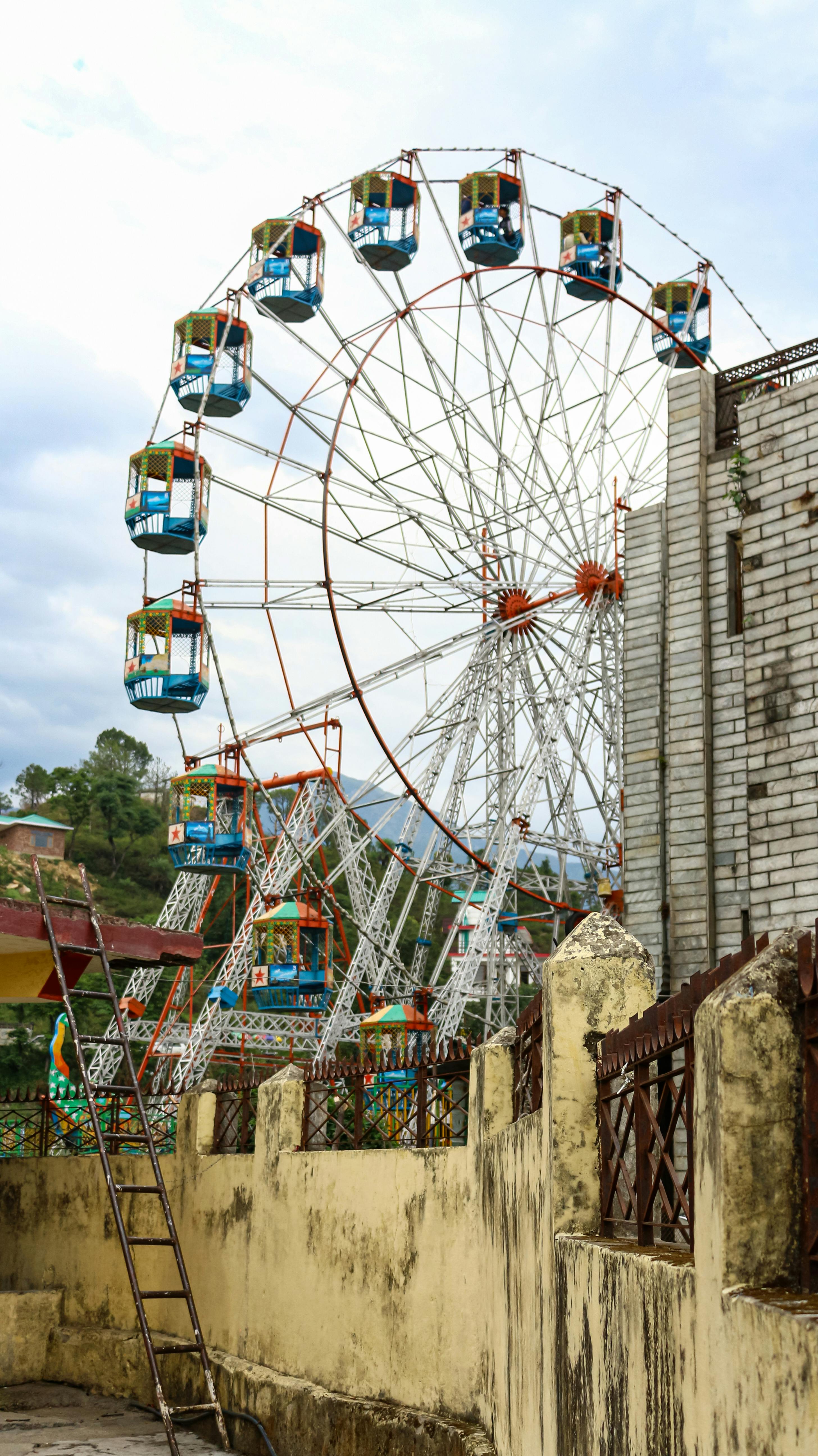 Ferris Wheel Near Brown Concrete Building · Free Stock Photo