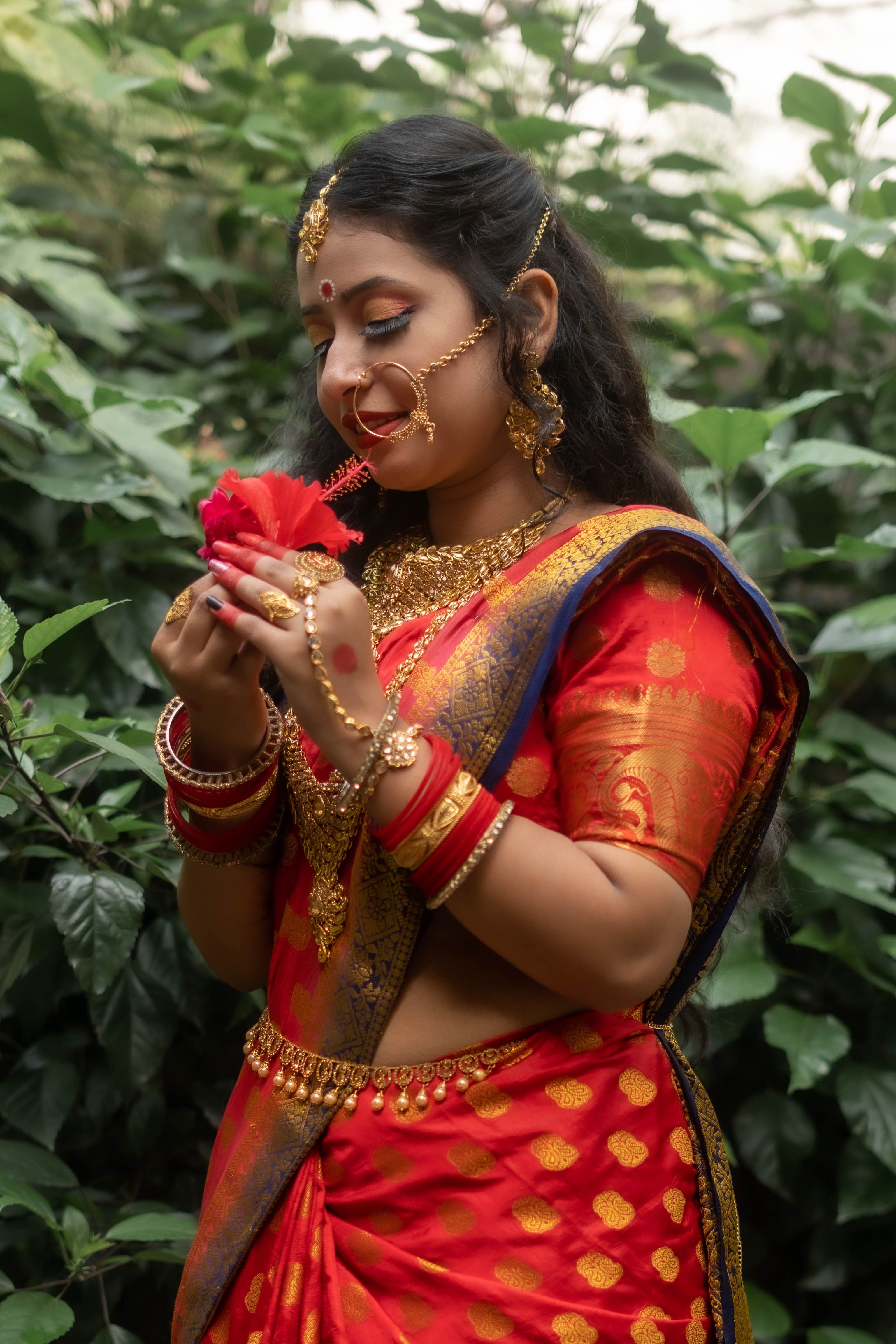 A Woman in Yellow and Red Sari Holding a Plate of Food · Free Stock Photo
