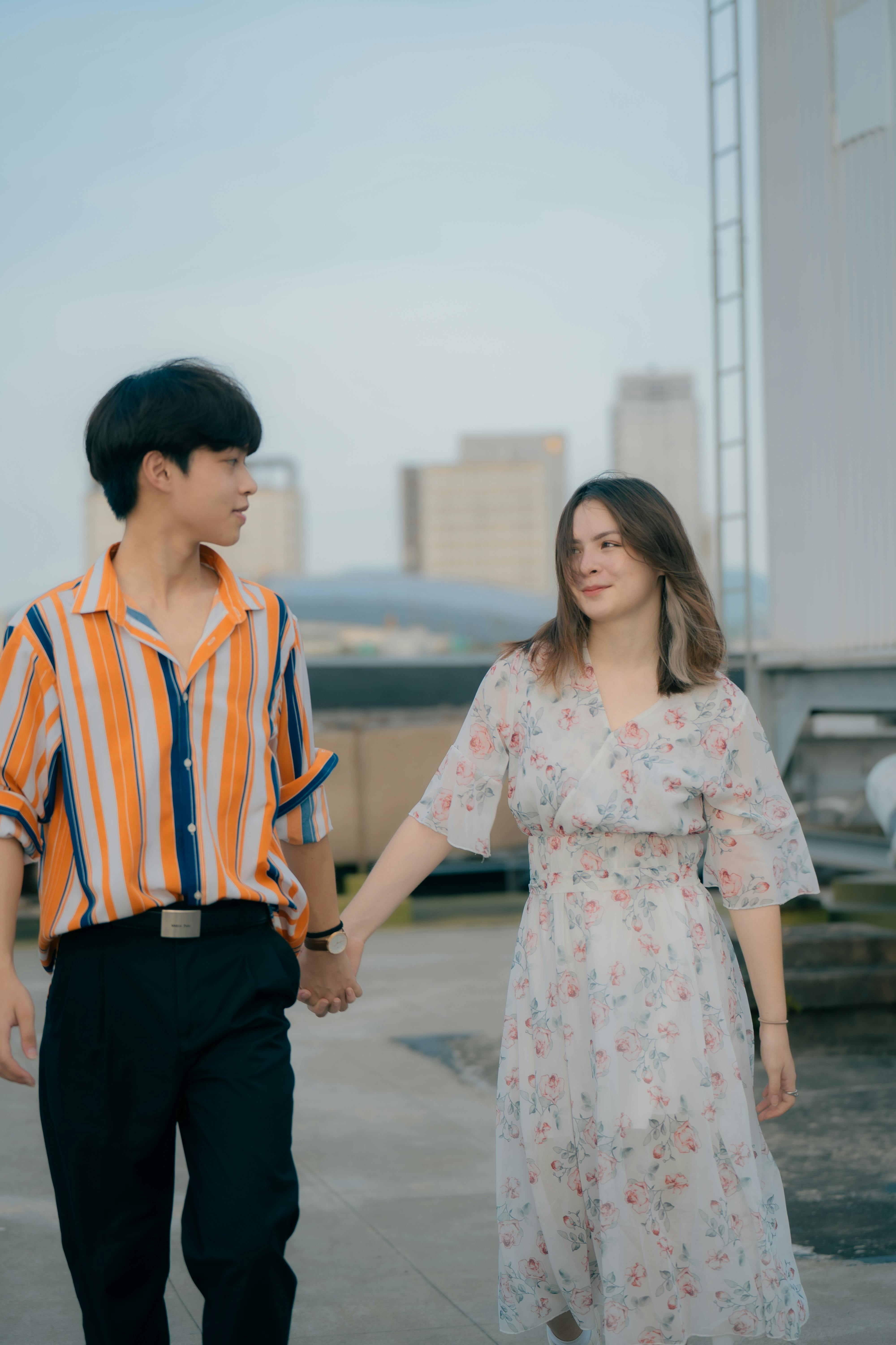 A Couple Holding Hands while Standing on the Roadside · Free Stock Photo