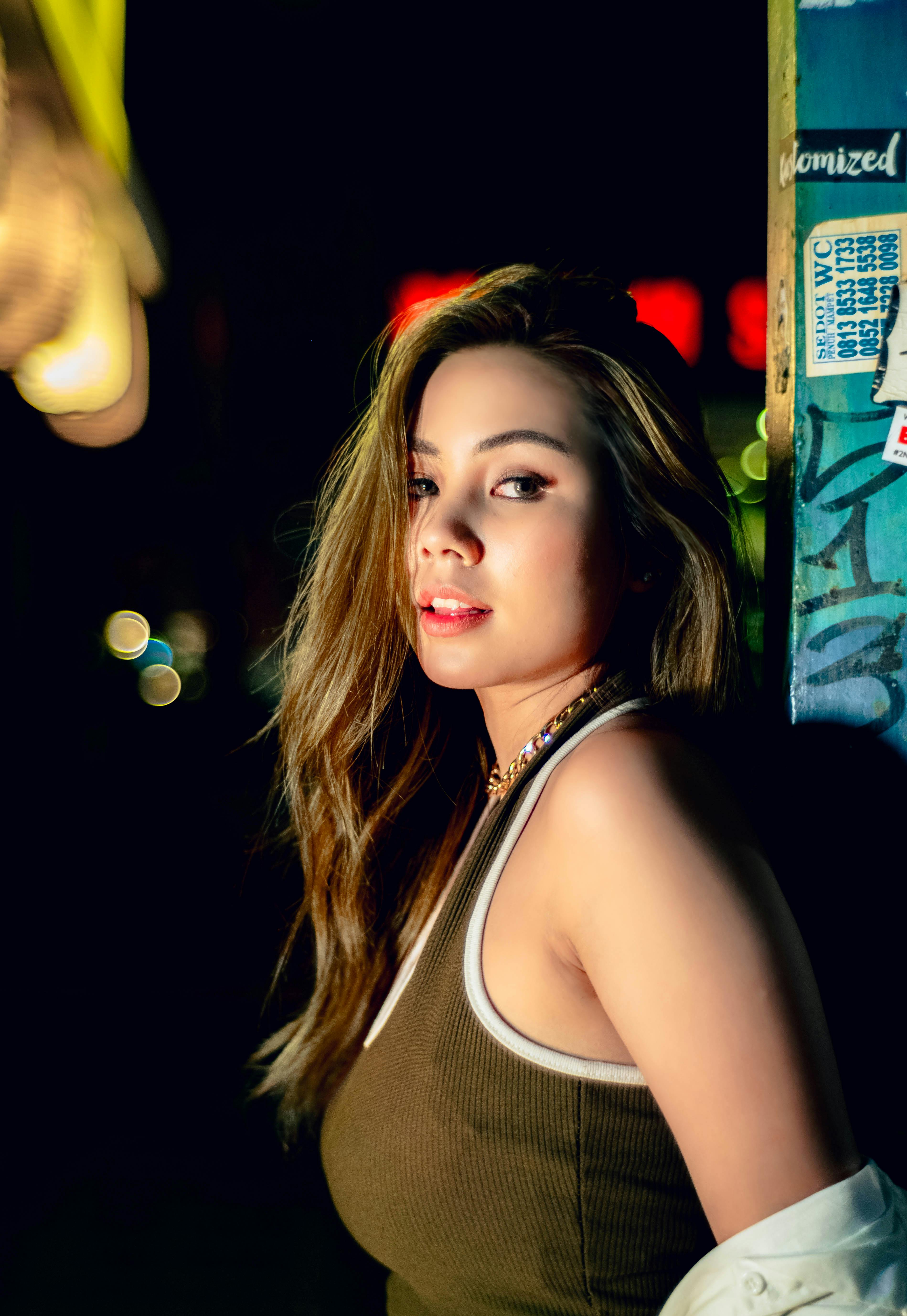 Woman in Green Tank Top Leaning on Wall · Free Stock Photo