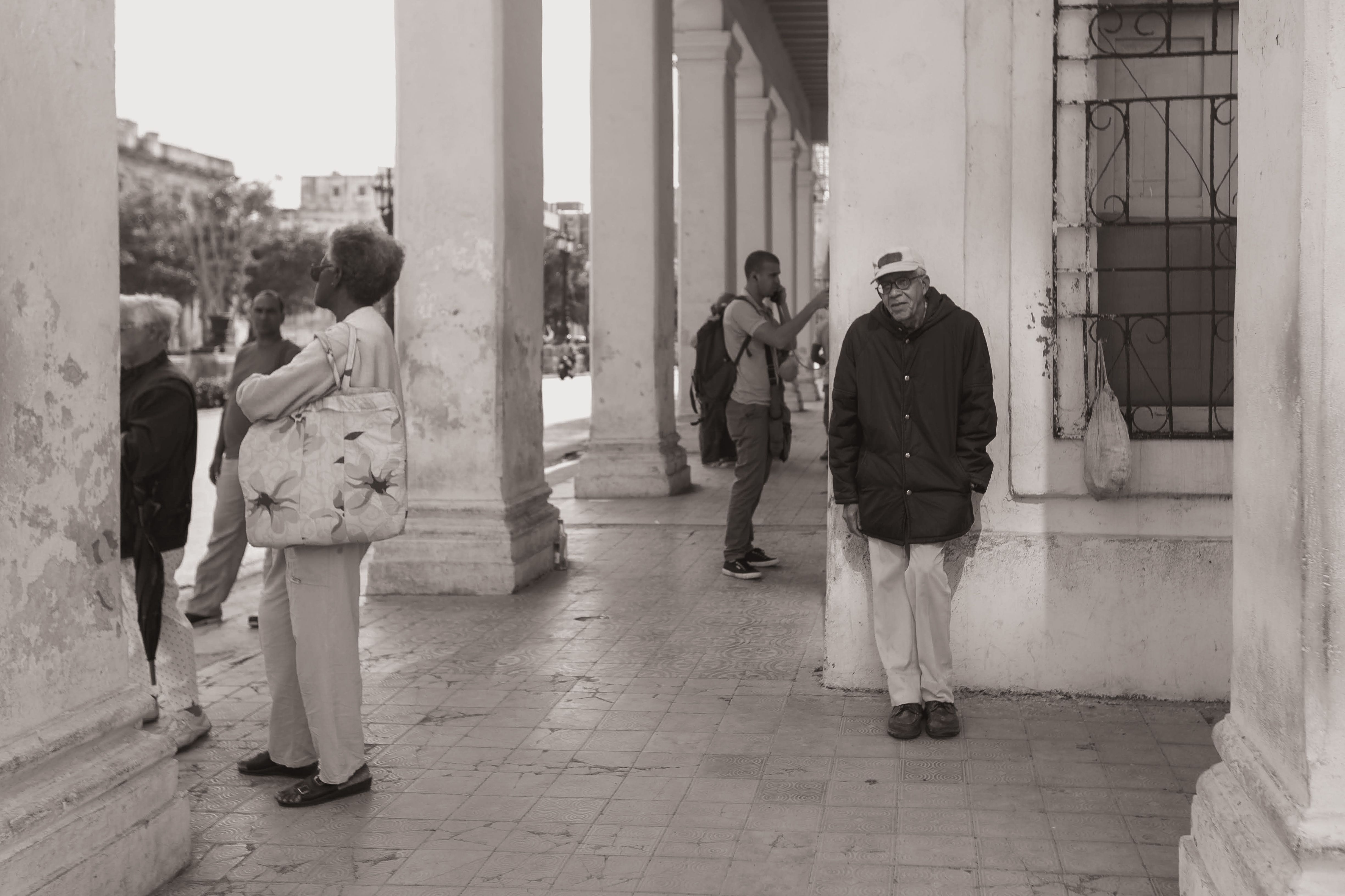 Sepia Toned Image of People Standing under Pillars · Free Stock Photo