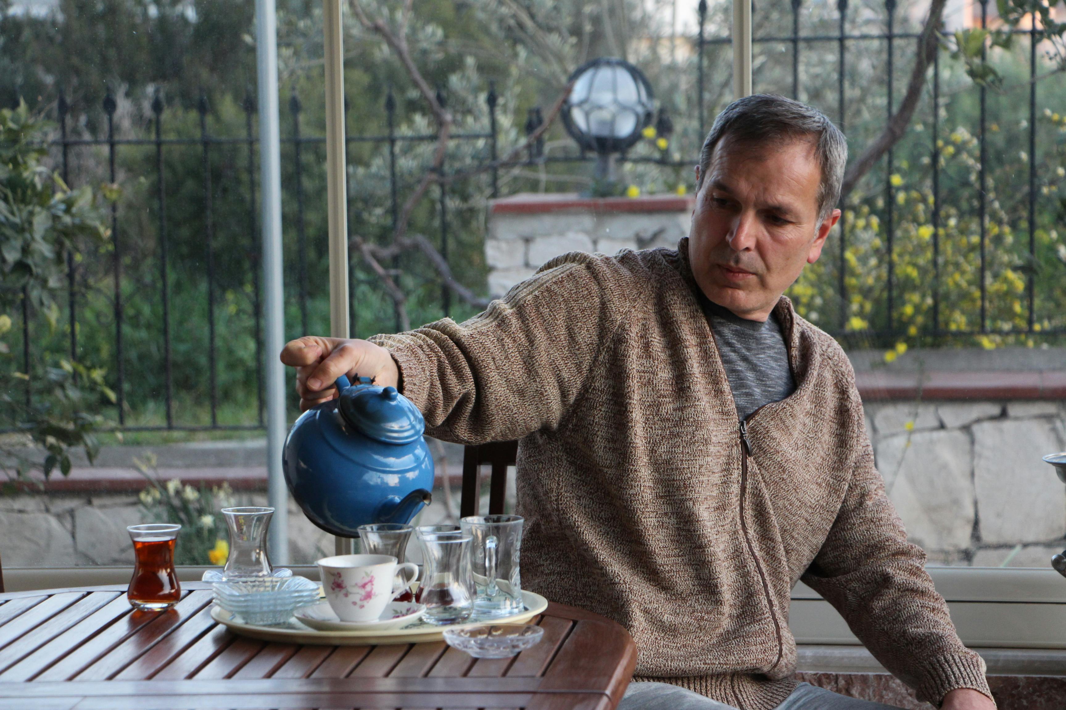 Man Preparing Tea on a Terrace · Free Stock Photo