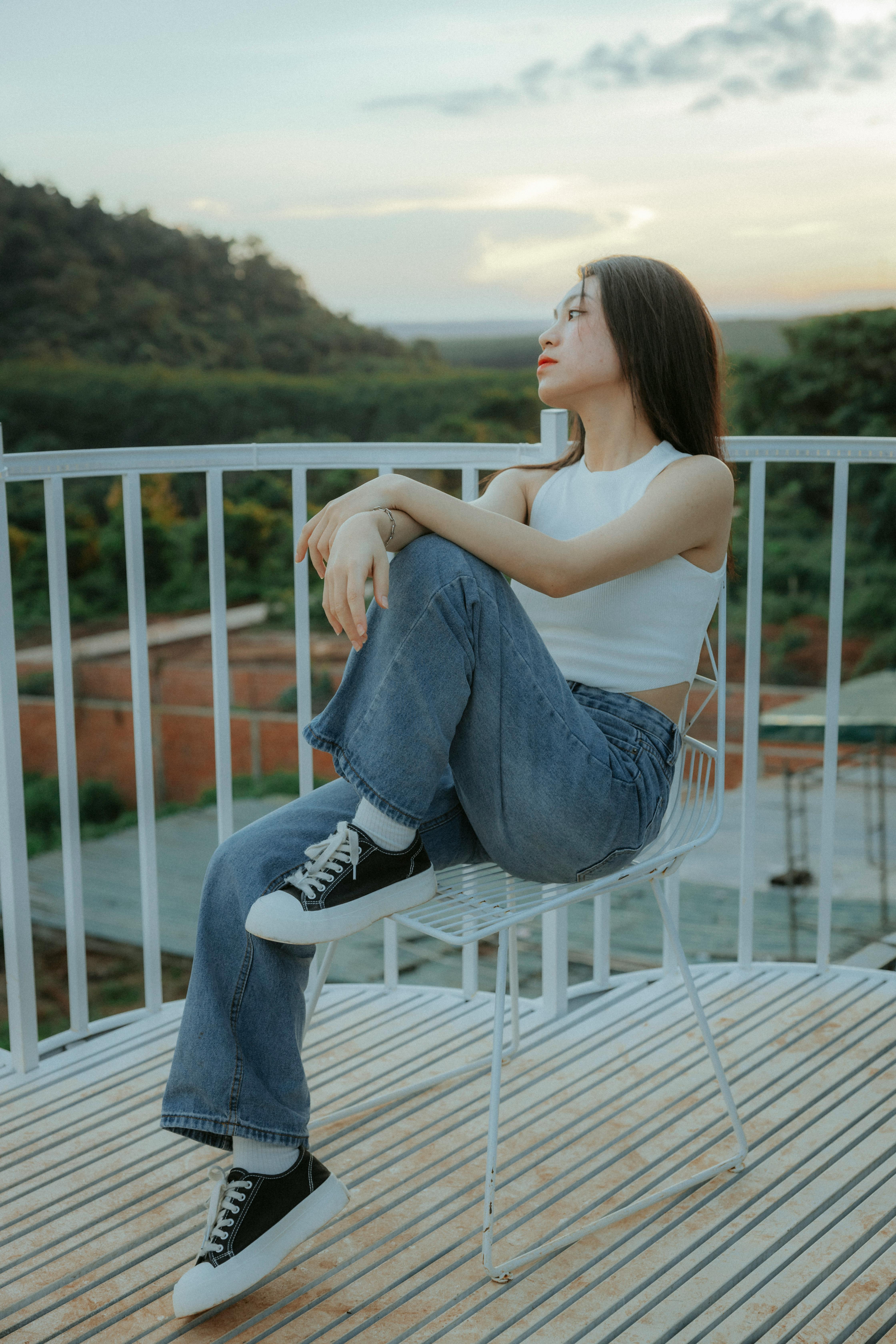 Woman Sitting on Chair Wearing Jeans and Top · Free Stock Photo