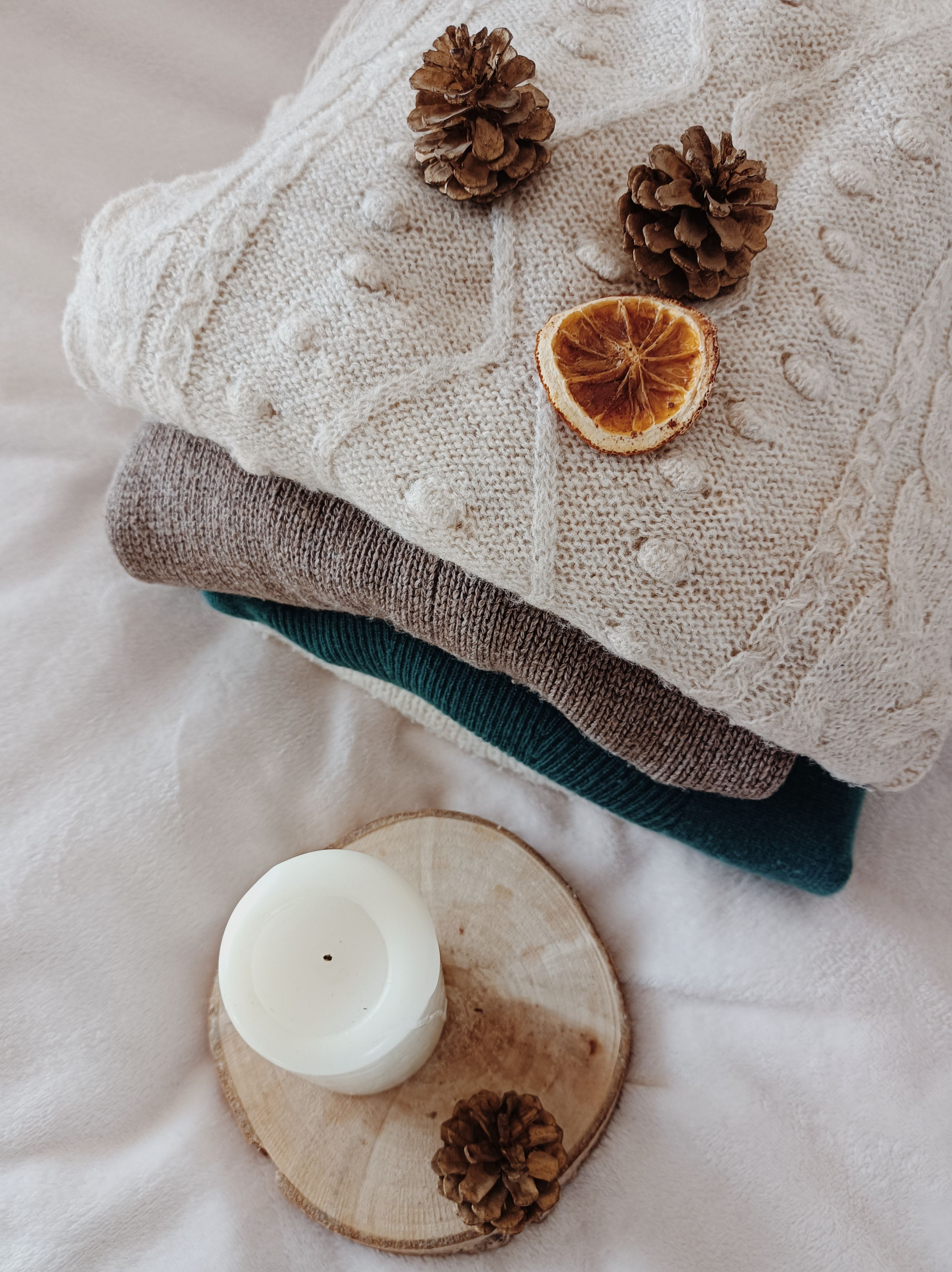 Sweaters and Fall Decor on White Fabric · Free Stock Photo