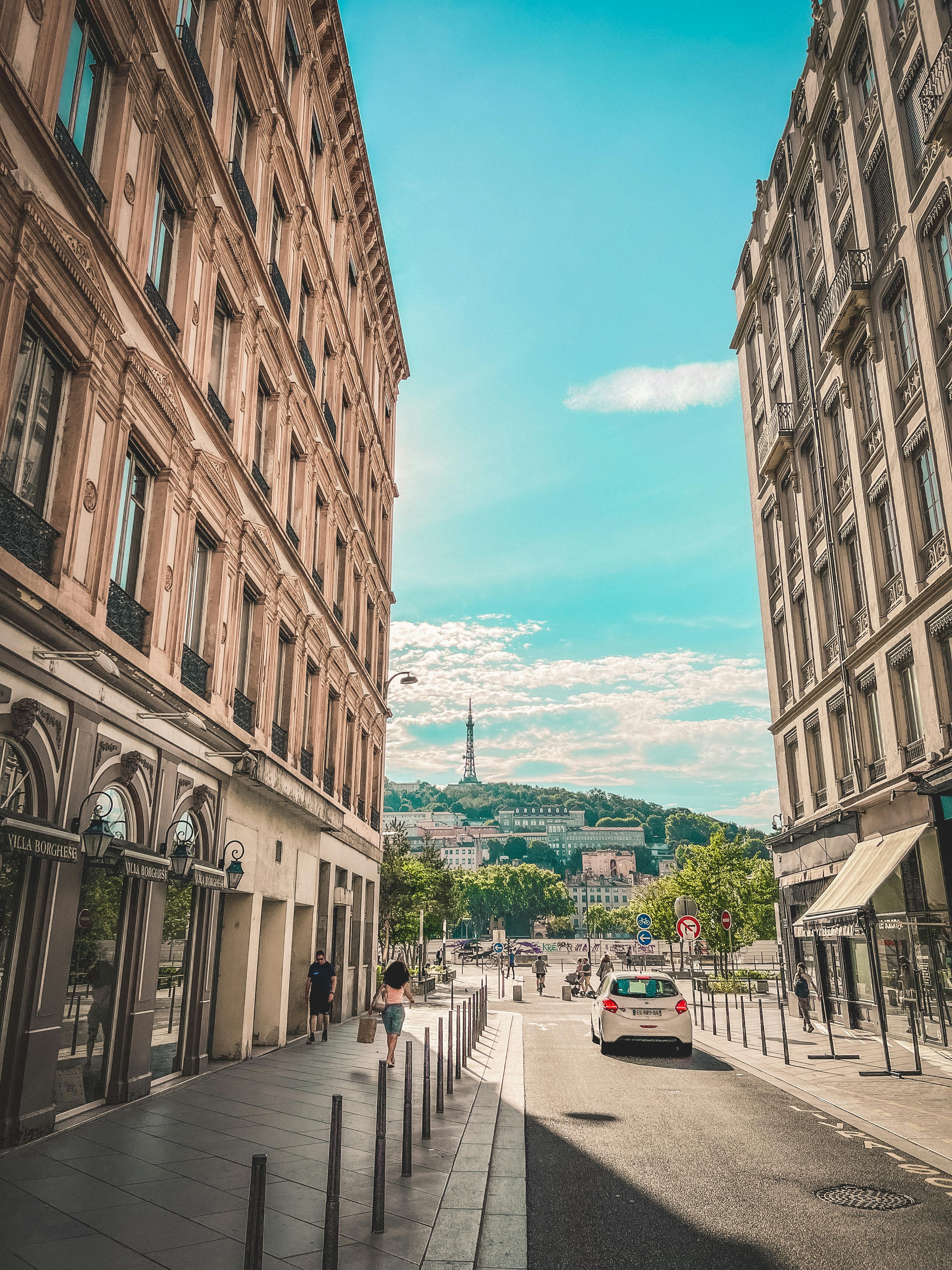 Urban Street between Buildings with the View of a Tower in Distance ...