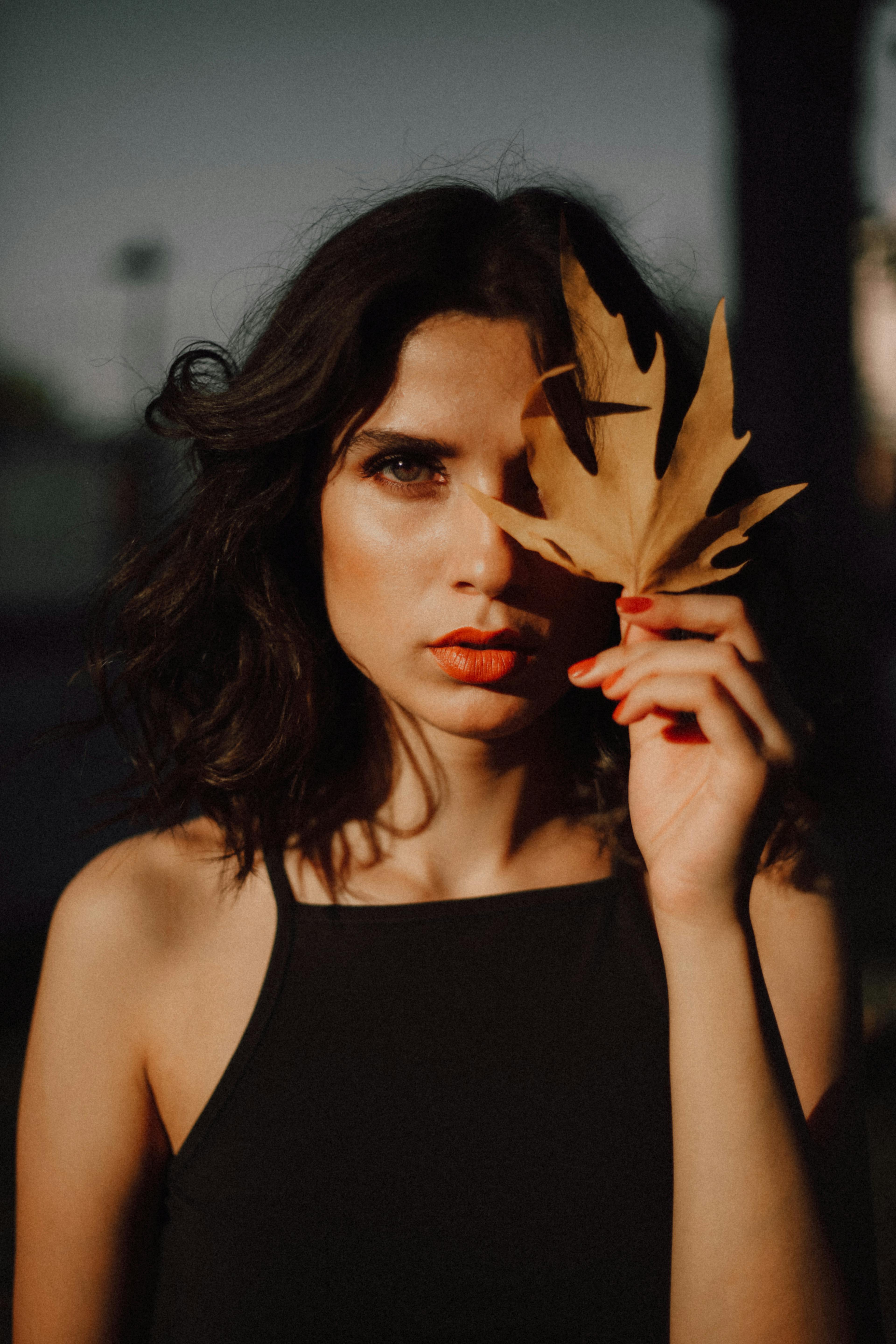 Brunette Posing with Autumn Leaf · Free Stock Photo