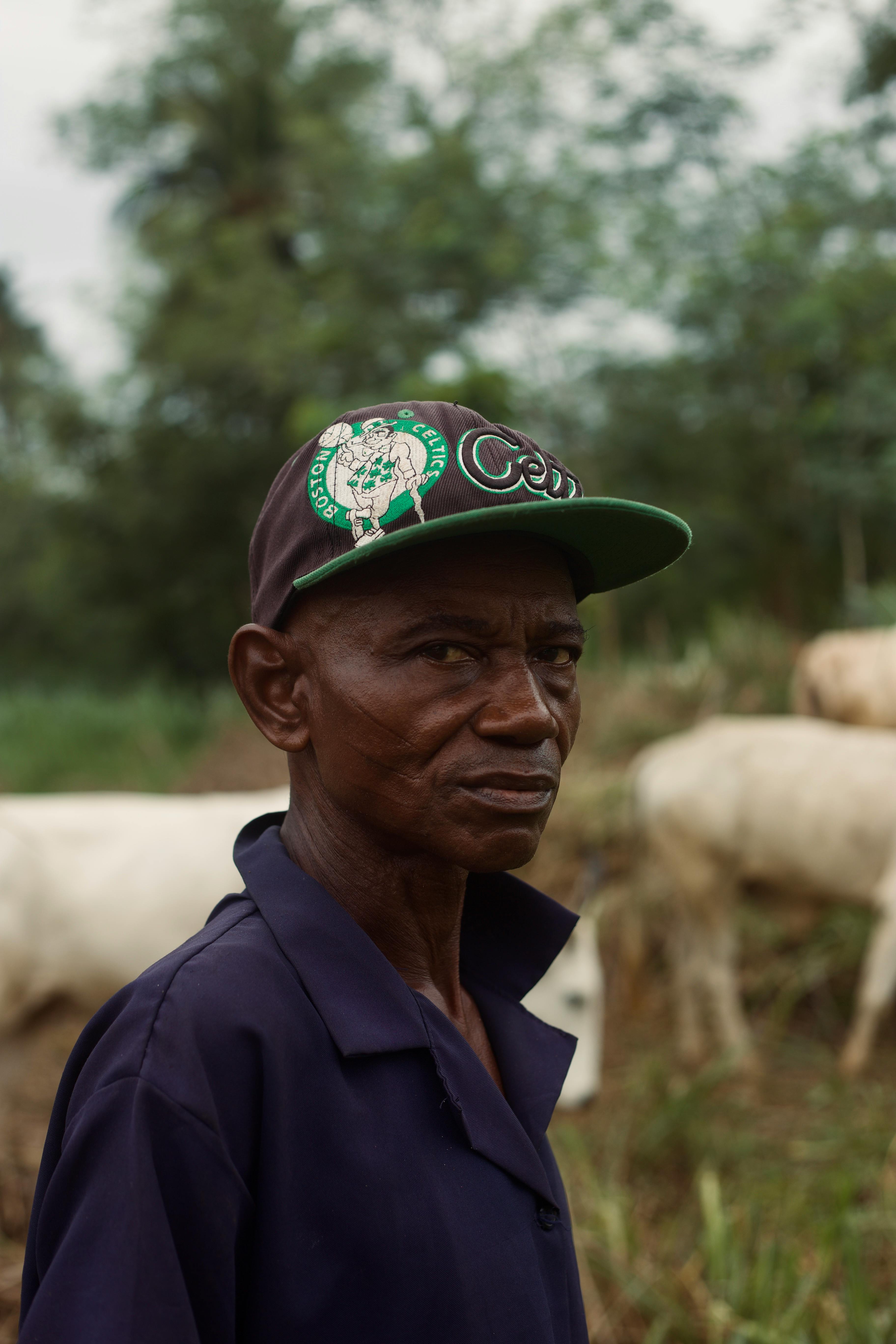 Man Wearing a Cap Standing on a Pasture · Free Stock Photo
