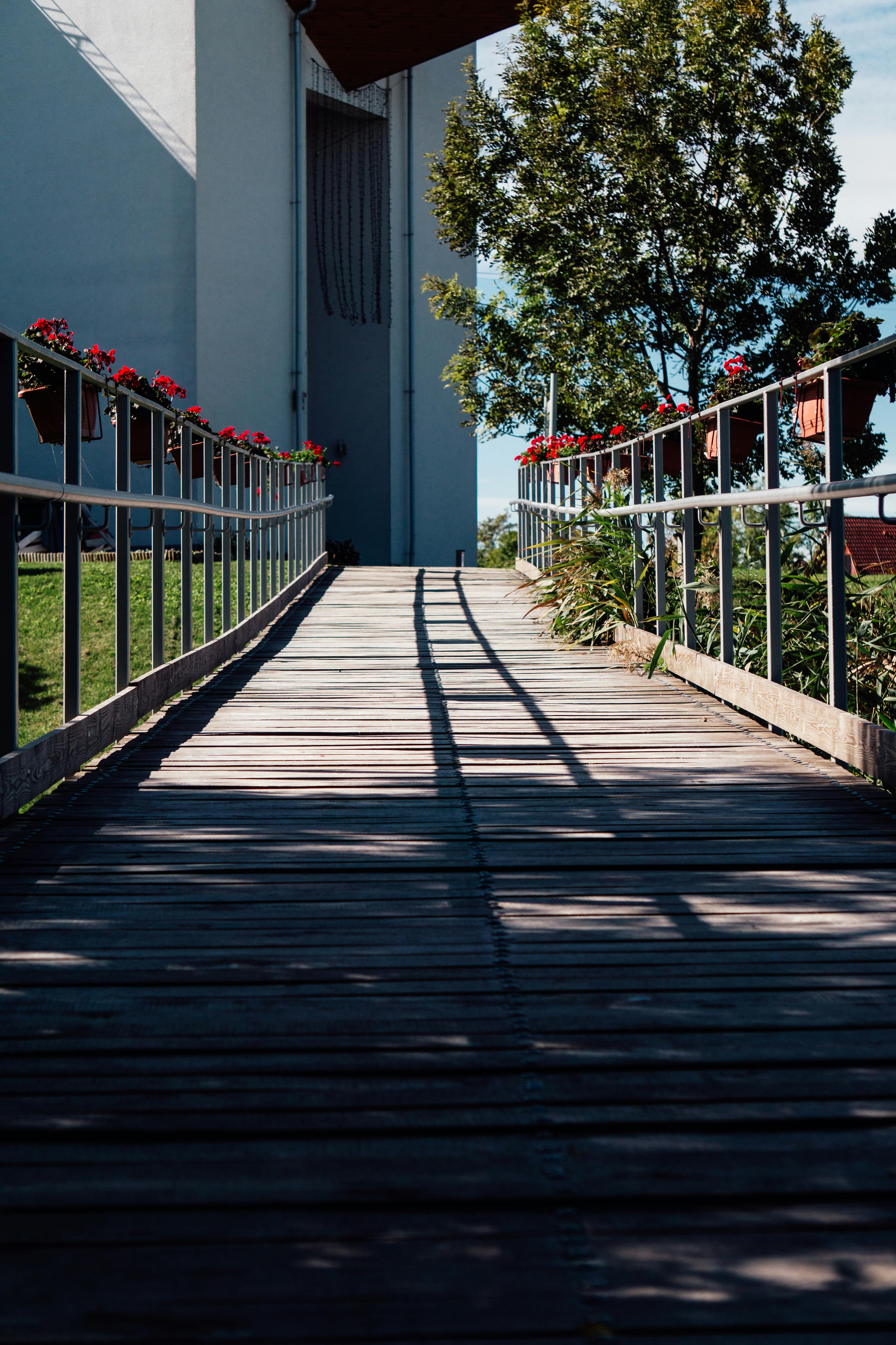 Wooden Footbridge Decorated with Flowers on the Railing · Free Stock Photo
