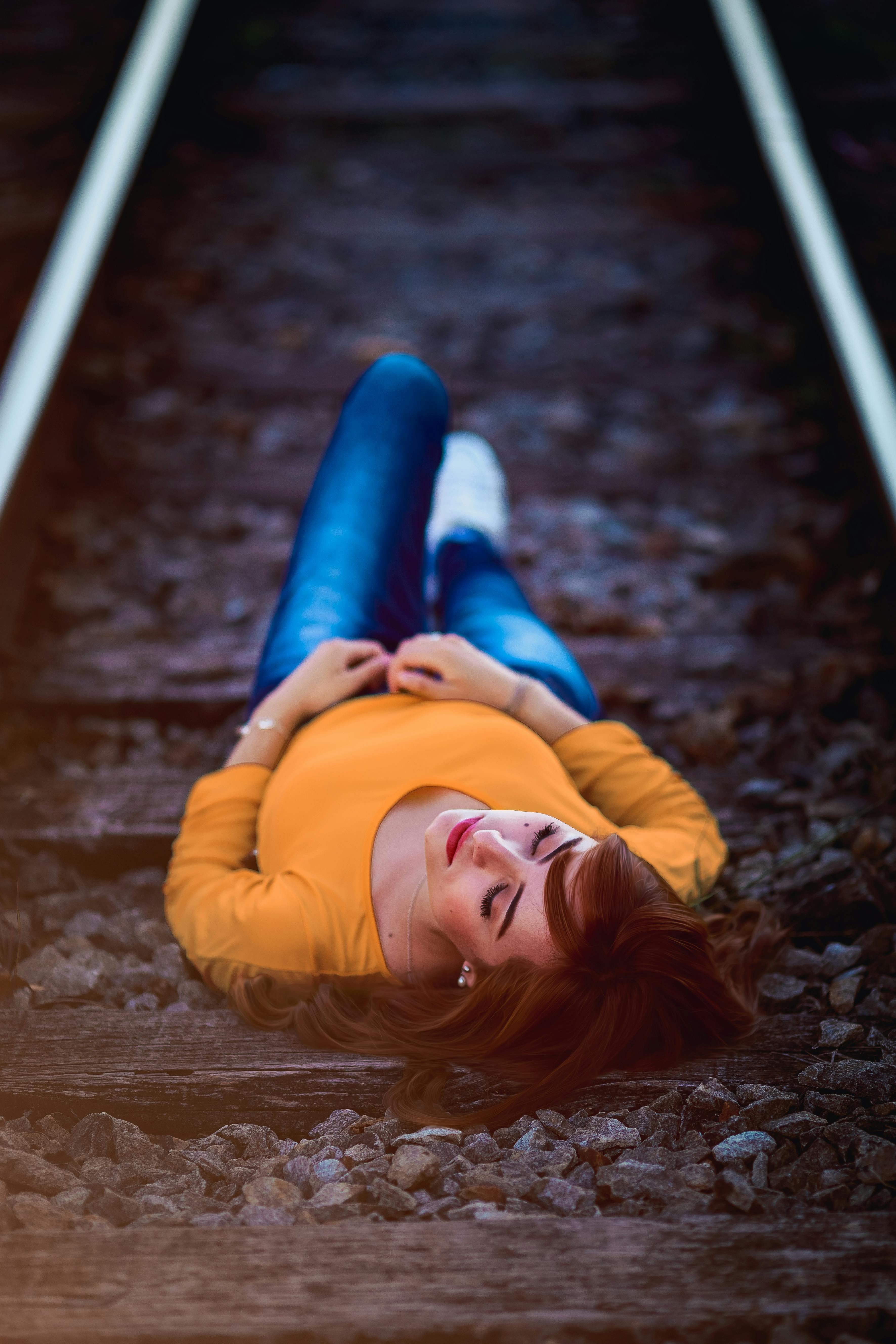 A Woman Lying Down on a Rail Track · Free Stock Photo