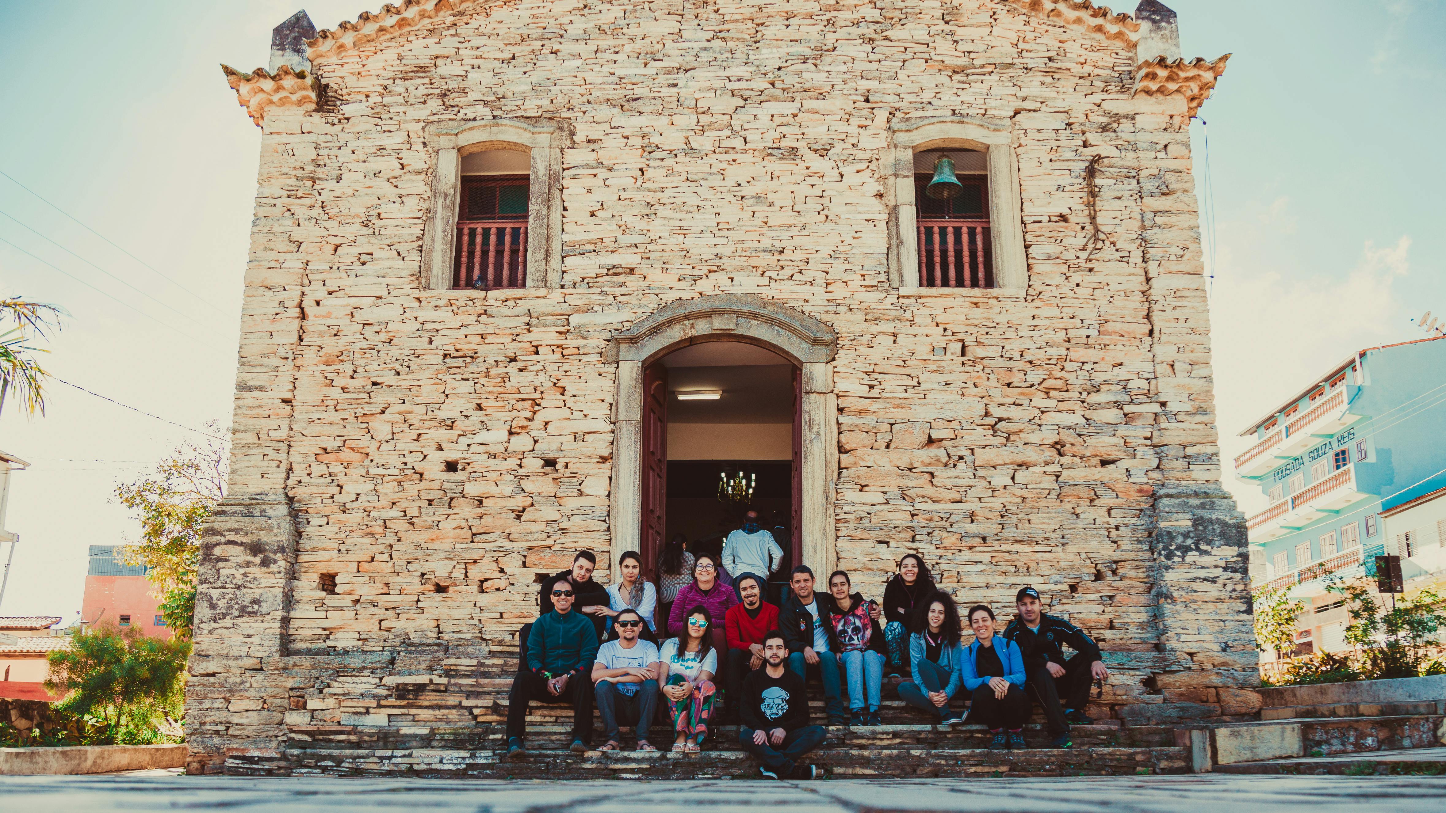 Group of People Sitting in front of a Church · Free Stock Photo