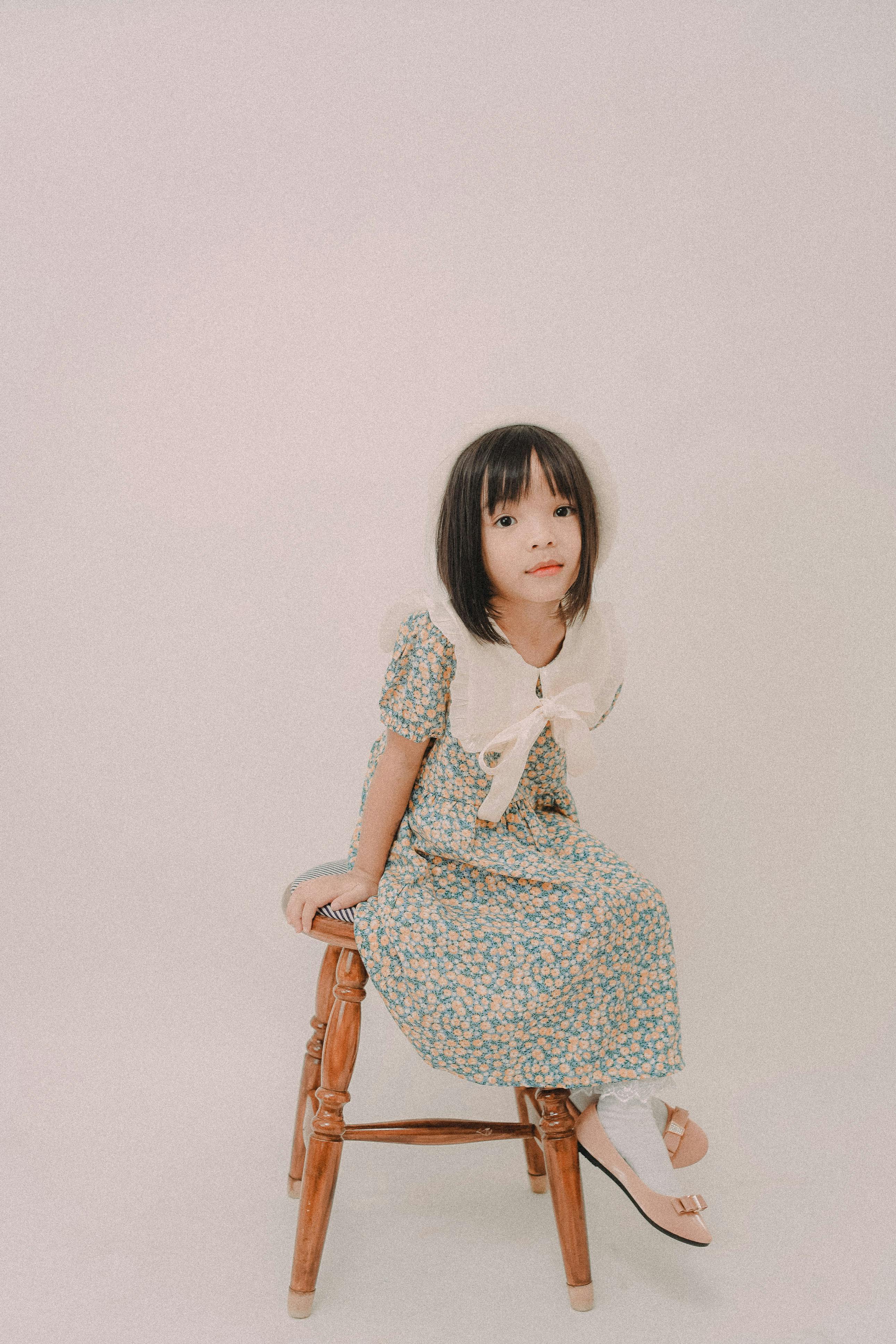 Girl in Floral Dress Sitting on a Chair · Free Stock Photo