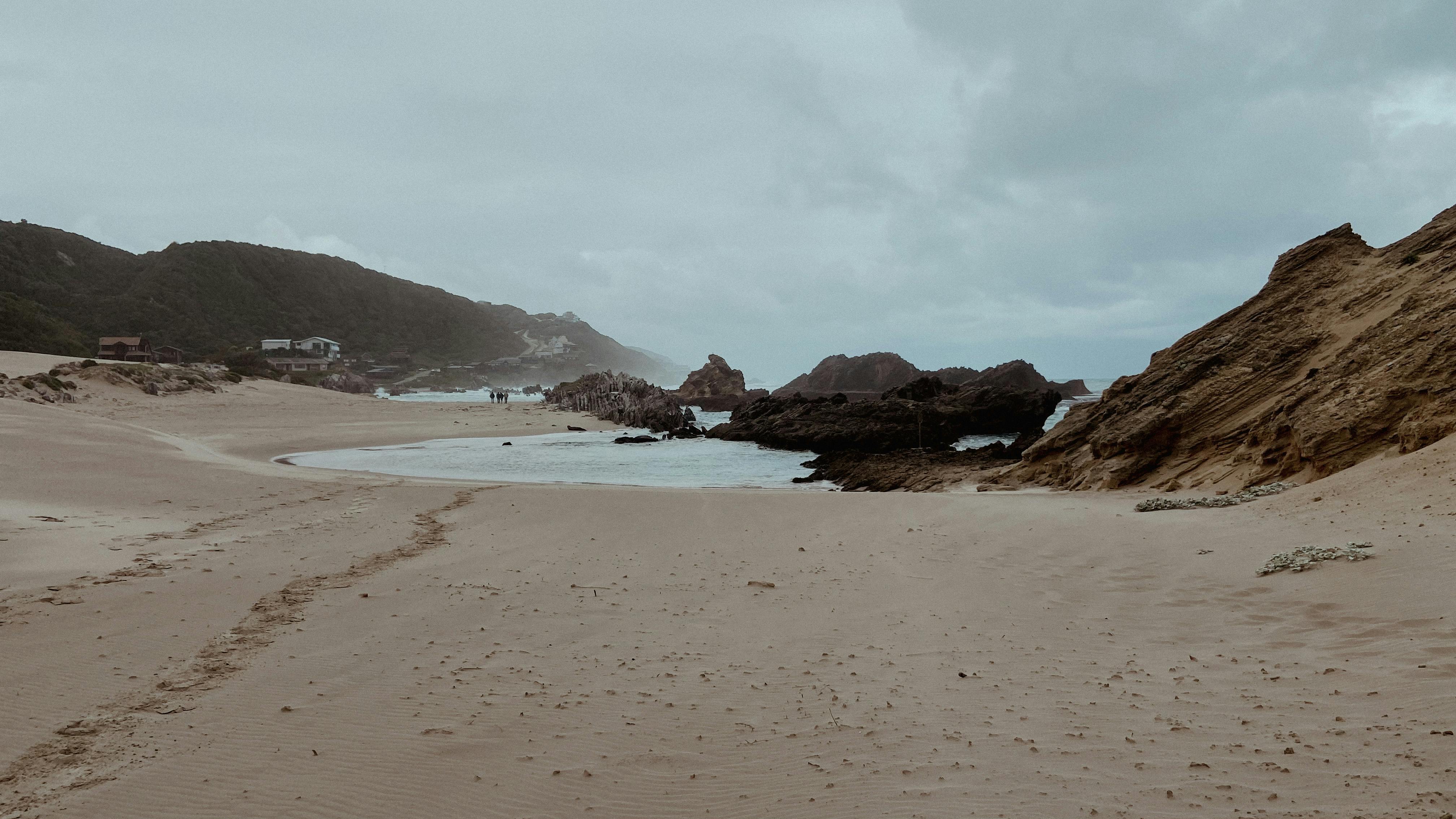 Rocks Separating Beach from Ocean · Free Stock Photo