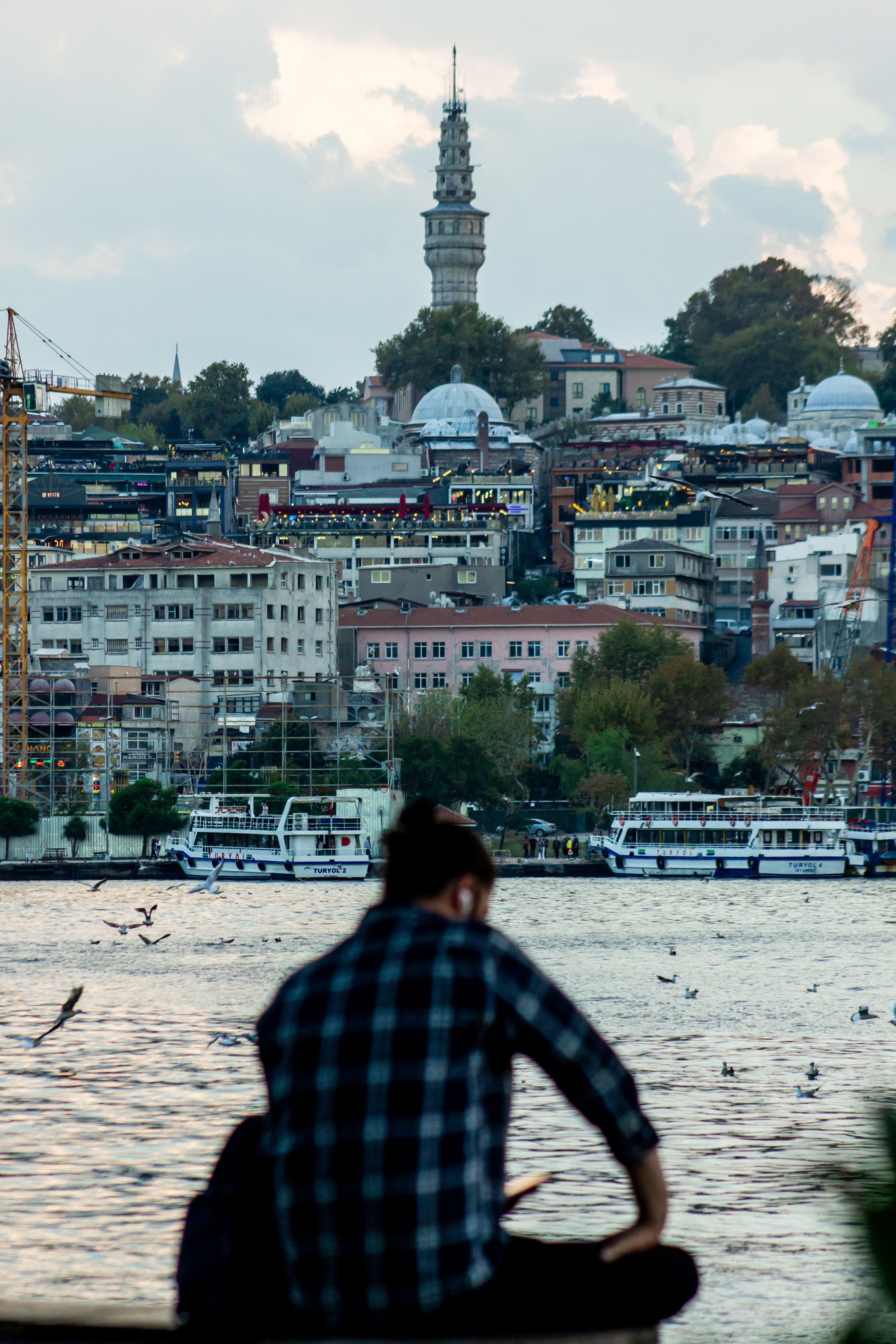 Back View of a Man Sitting on the Shore of the Bosphorus Strait in ...