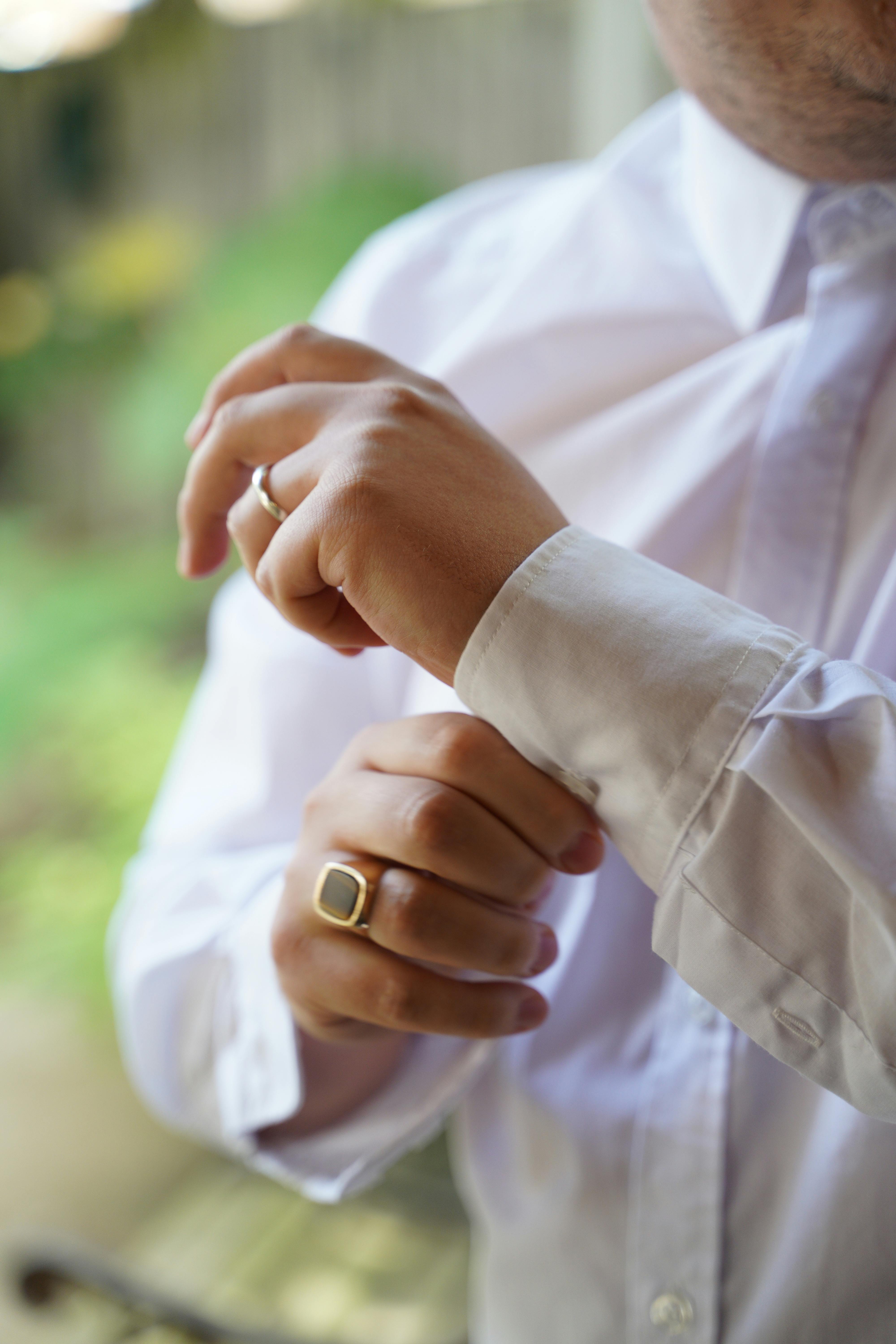 Man Buttoning his Shirt Cuffs · Free Stock Photo